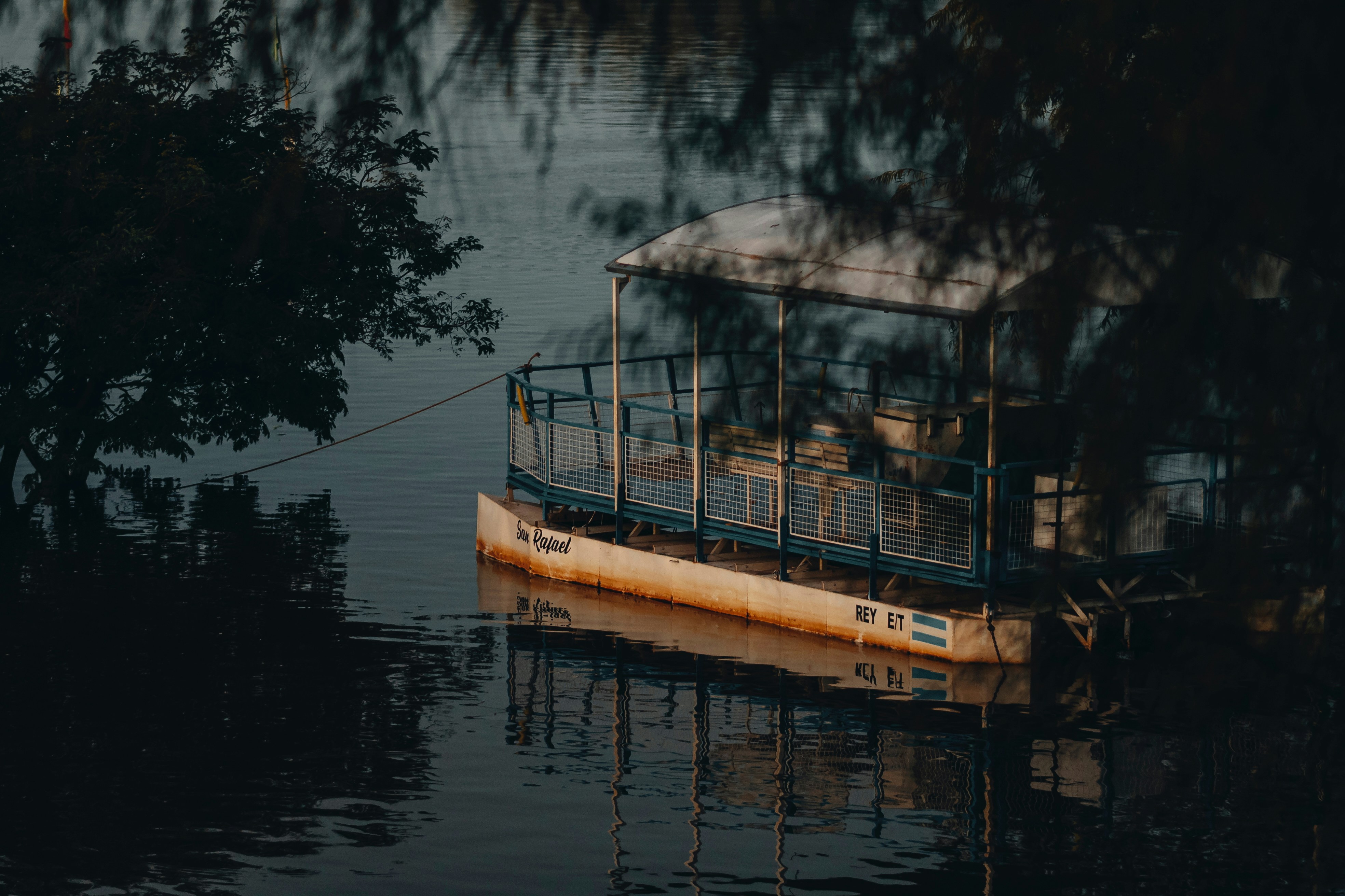 A boat rests calmly on the dark water.