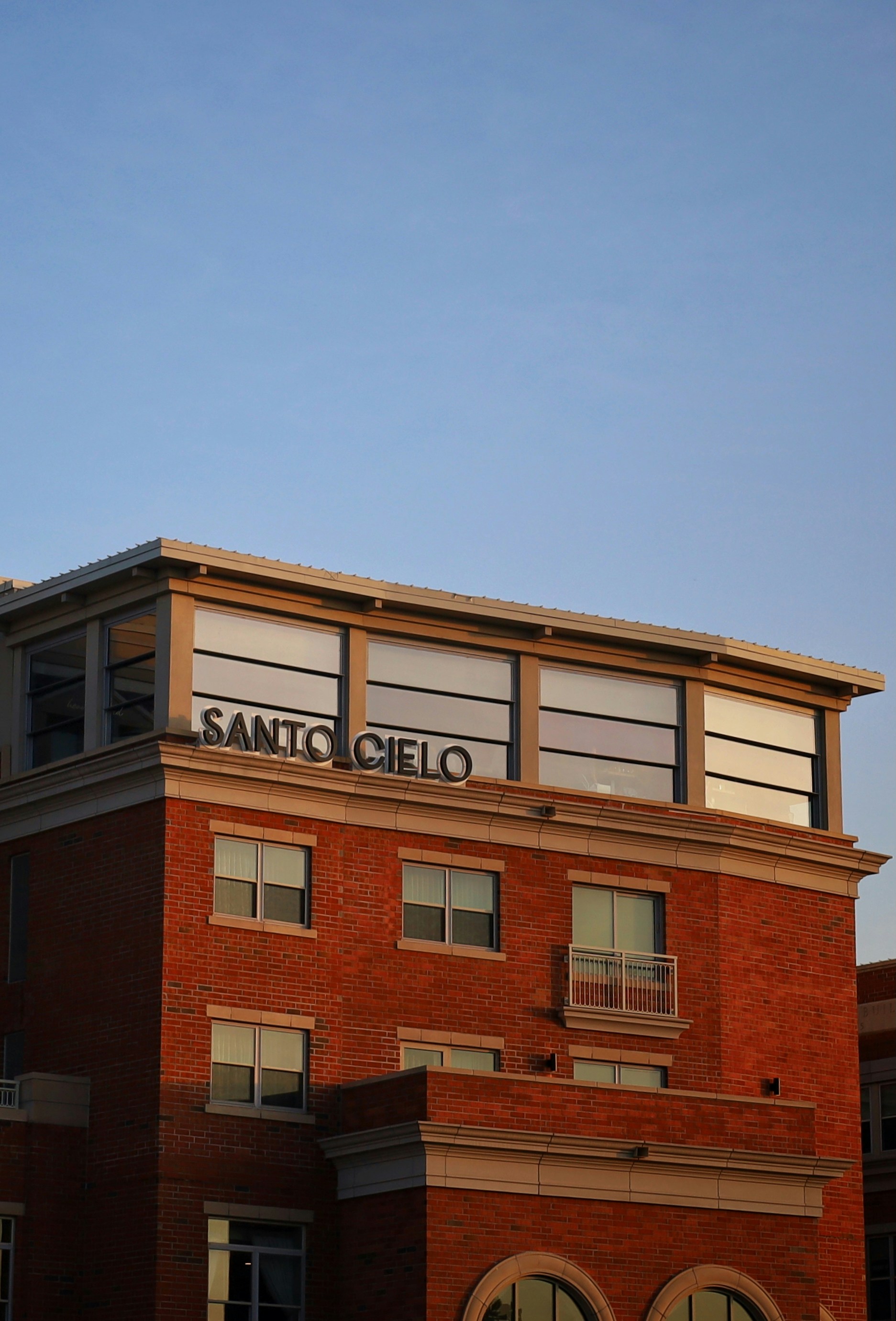Santo Cielo: Brick Facade Reaching Toward a Clear Blue Sky