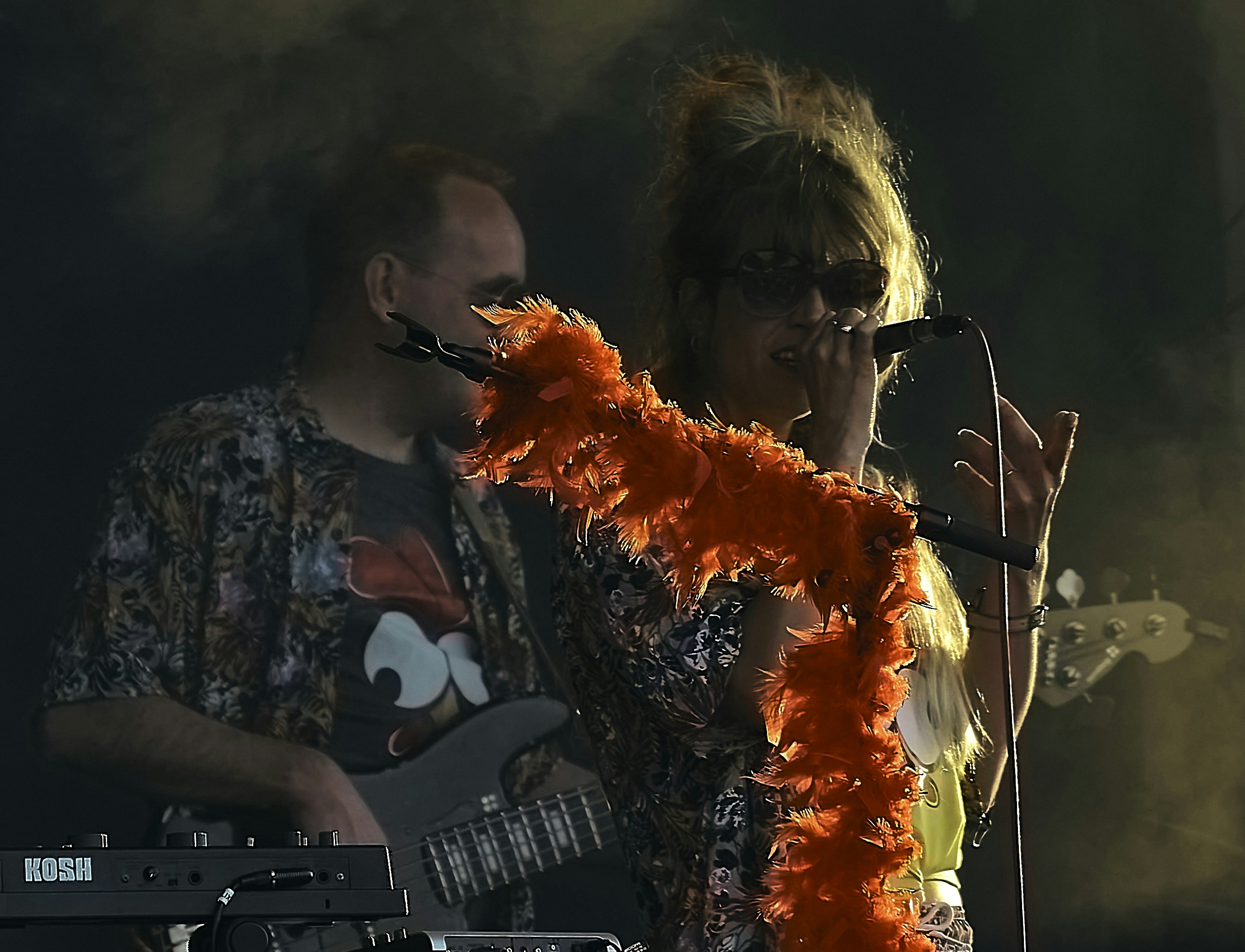A band performs on stage with a fuzzy boa. photo – Free Woman Image on ...
