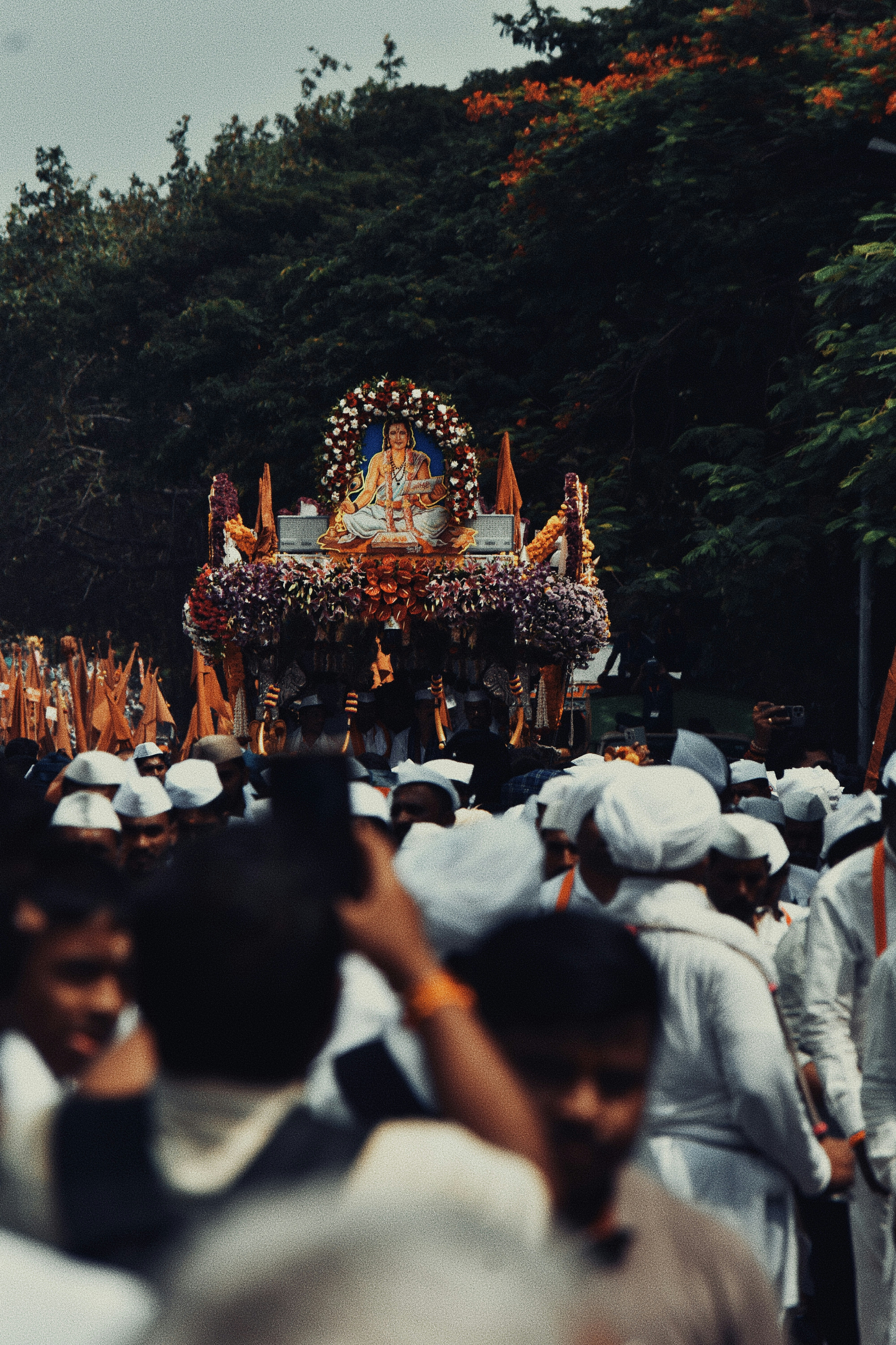 Floral Carriage of Devotion: A Sacred Statue Parade Through a Sea of White-Clad Devotees