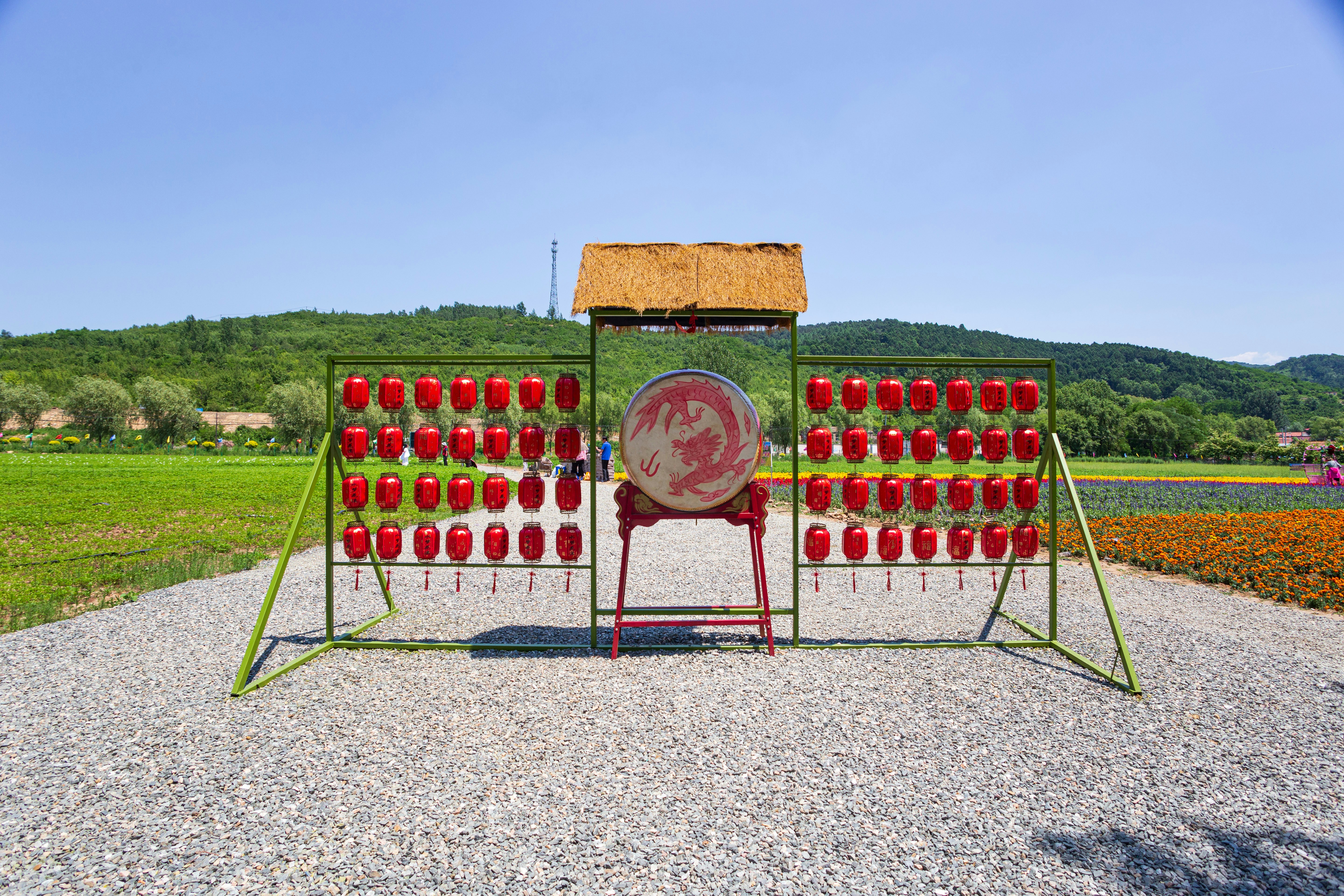 Gong at the Heart: A Lantern-Lined Target Framed by Red Ornaments on Gravel