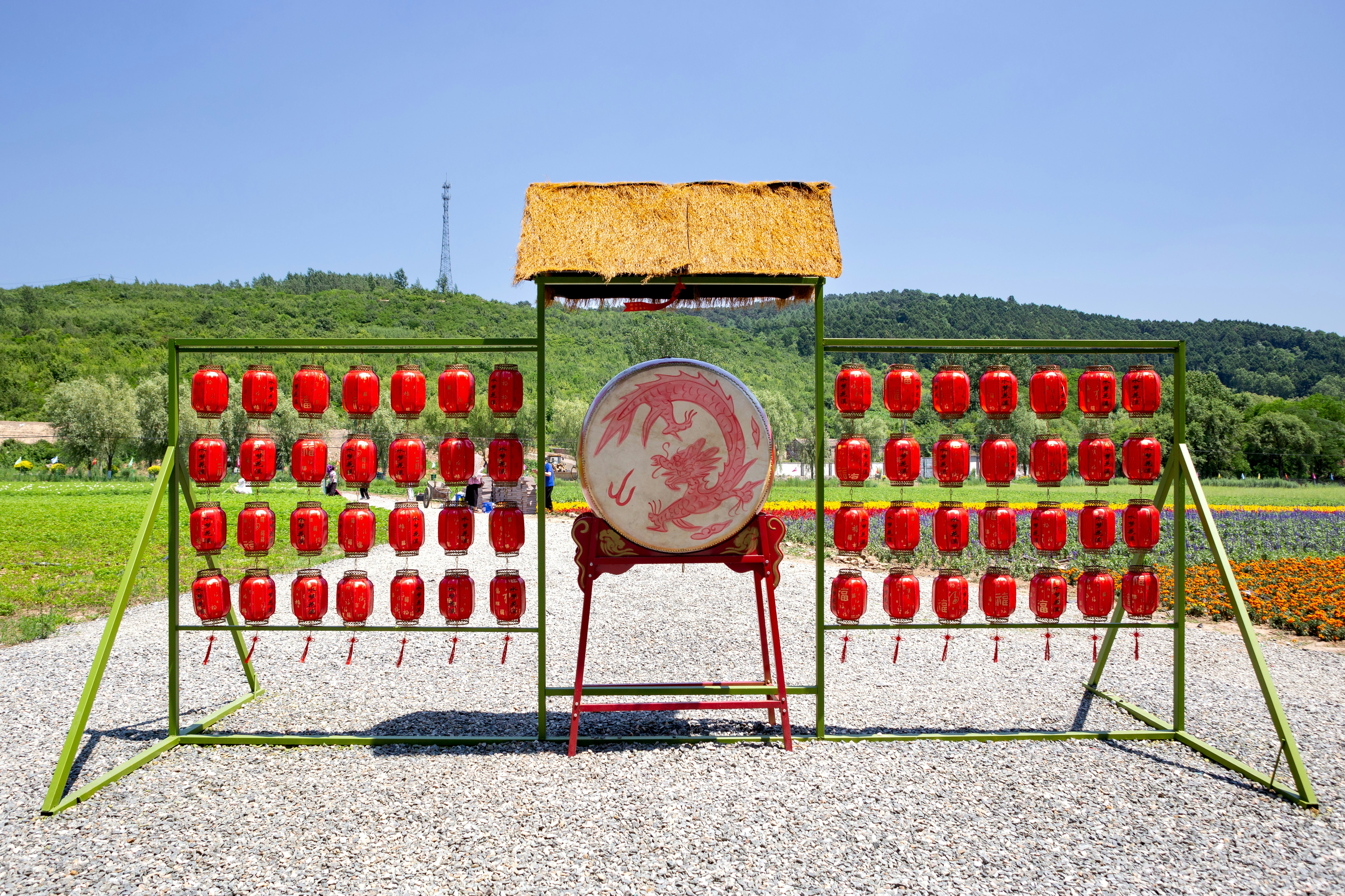 Symmetrical Taiko Drum Framed by Lantern Rows in a Sunlit Field