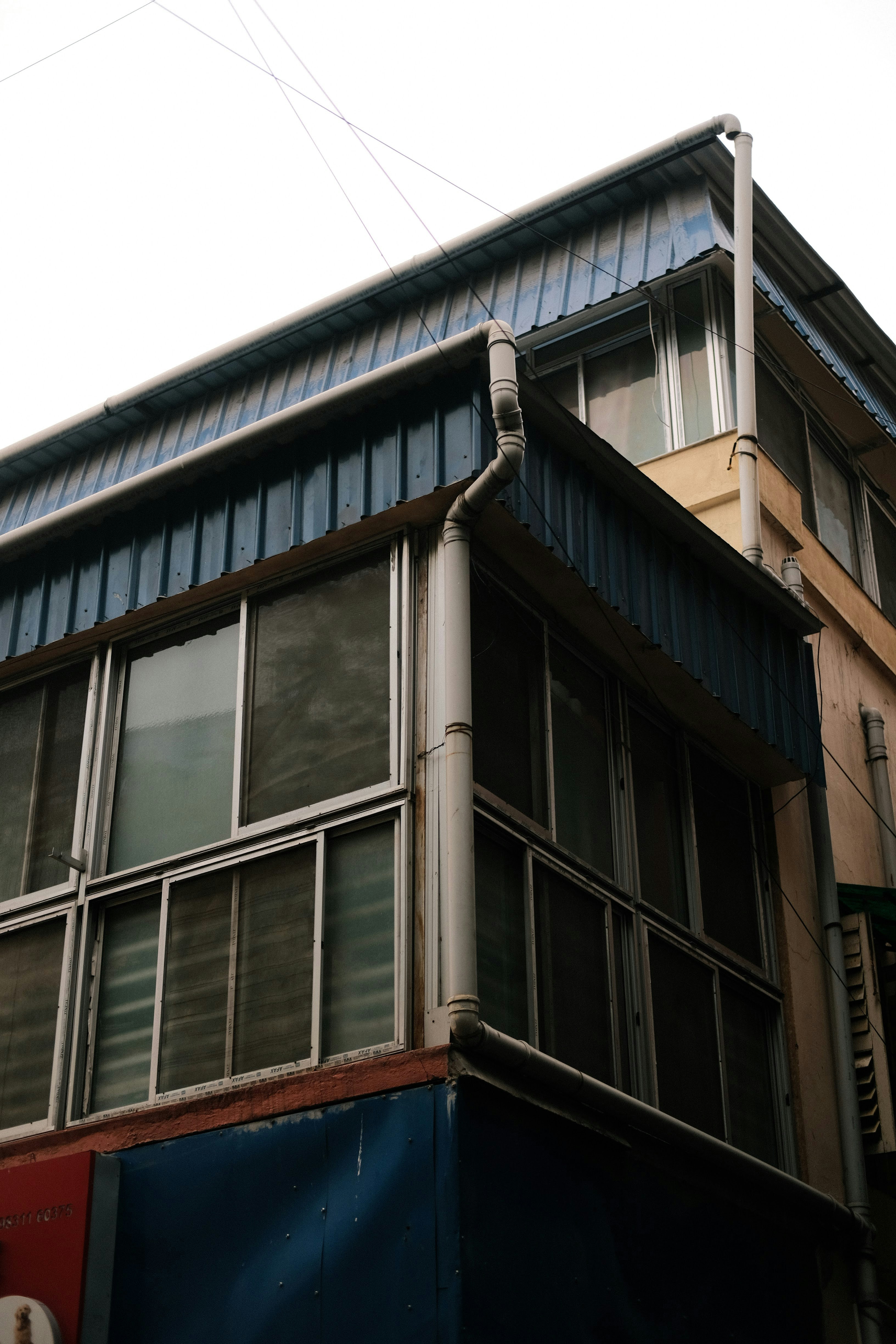 Buildings with blue accents against an overcast sky.
