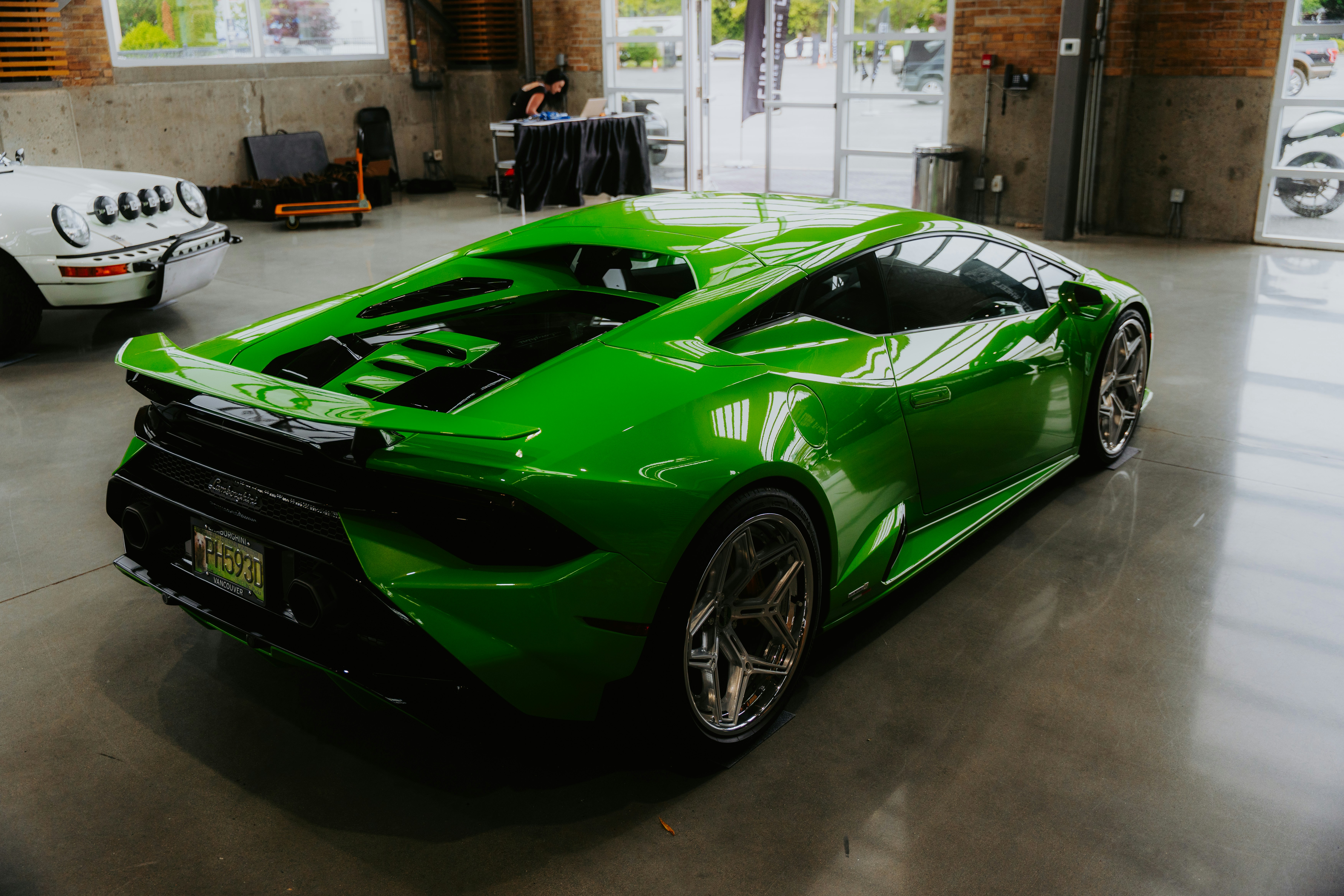 Emerald Huracan in a Quiet Showroom: a glossy mid-engine icon