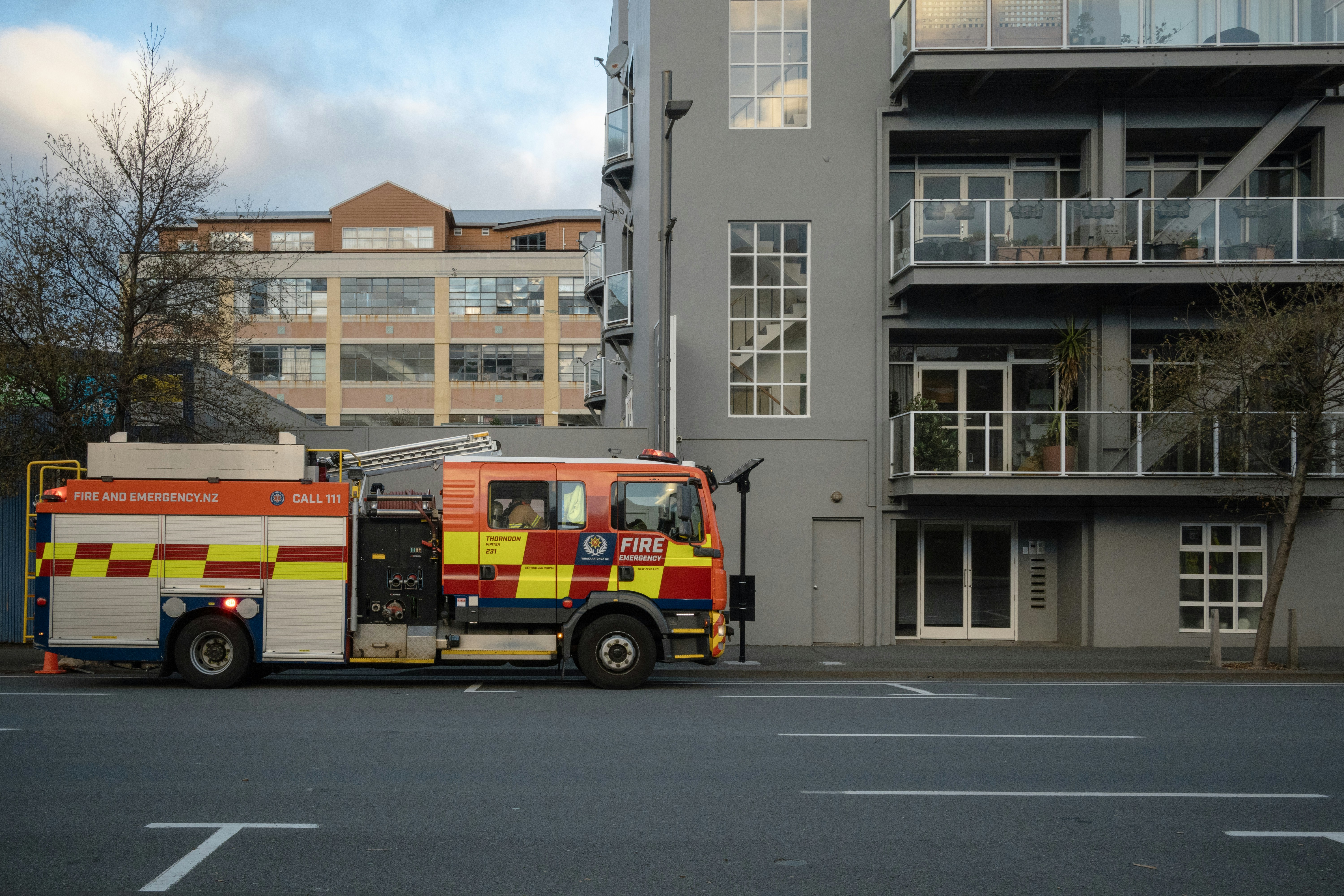 A firetruck is parked by a modern building. photo – Free Fire Image on ...