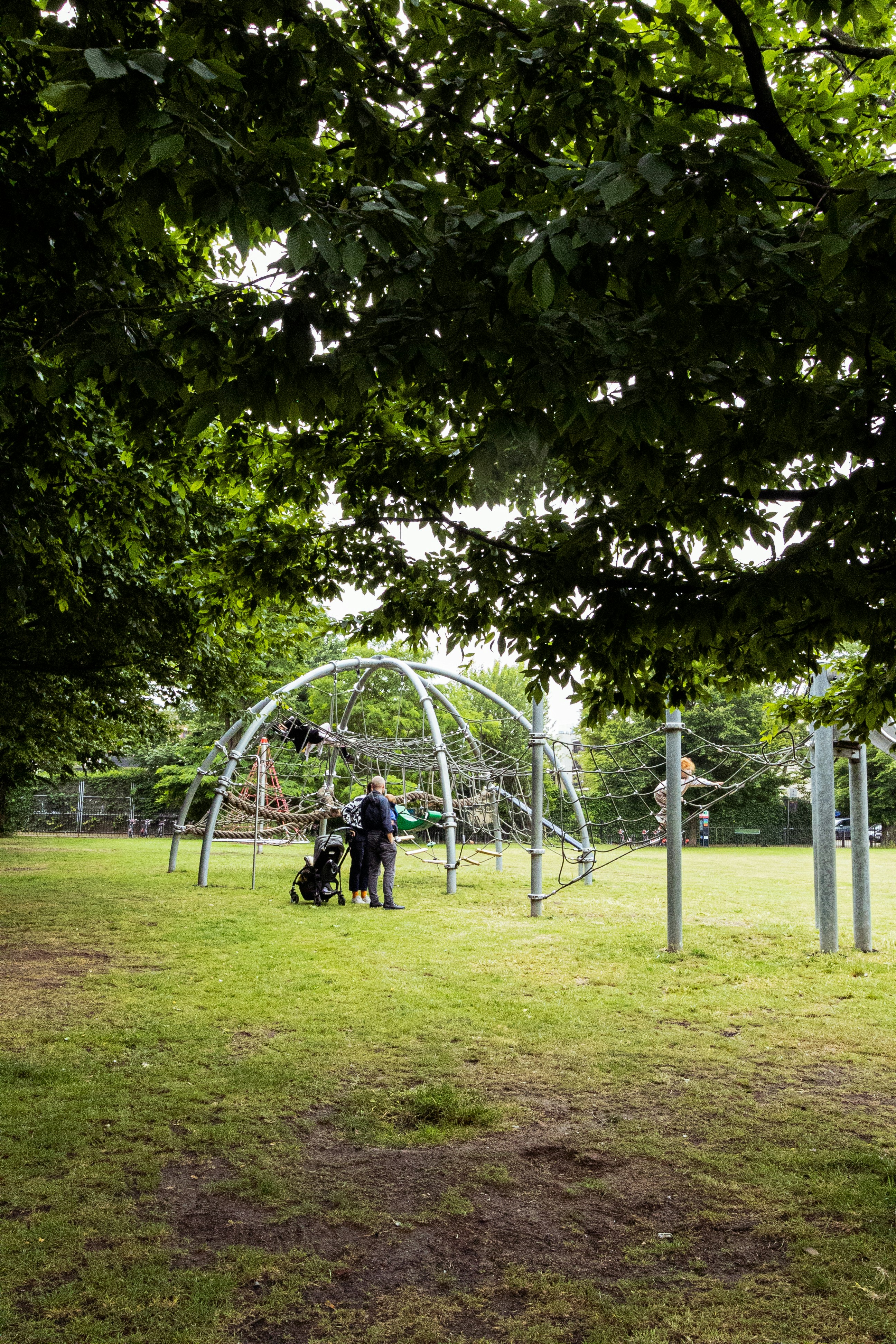 People enjoy a playground in a park.