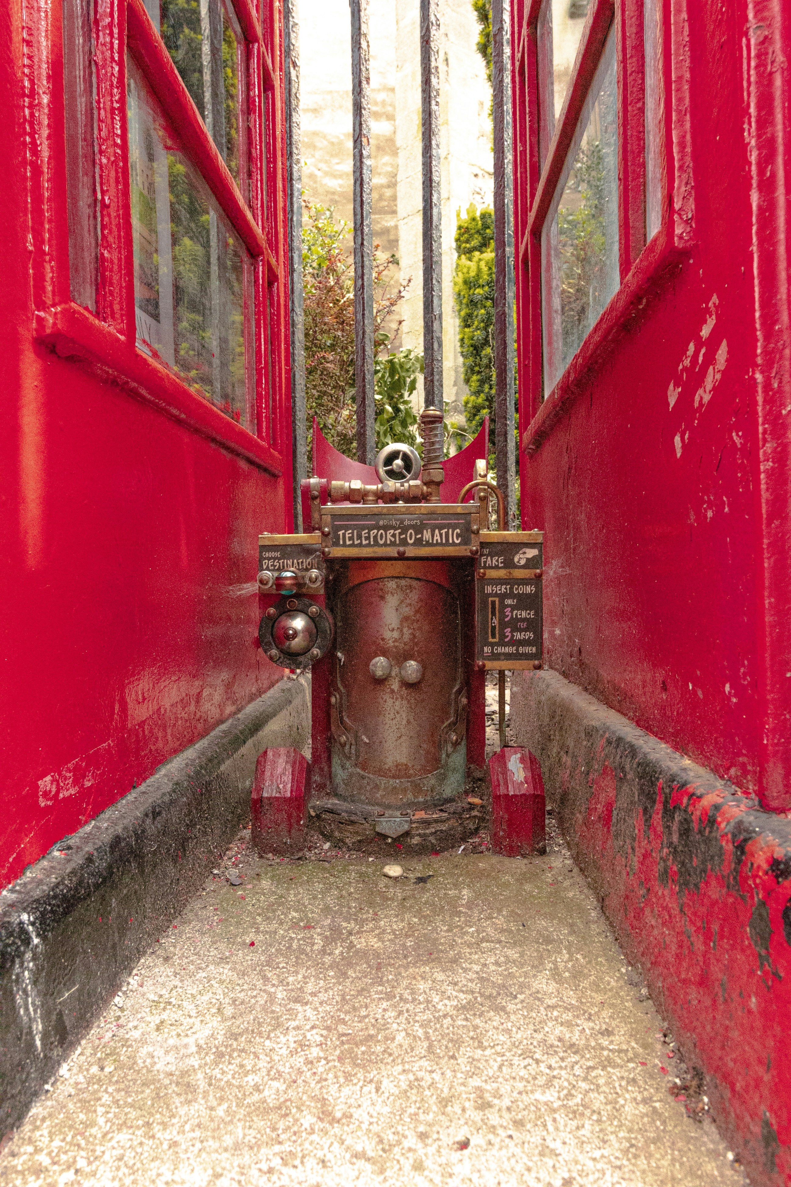 A small machine sits between red phone booths.