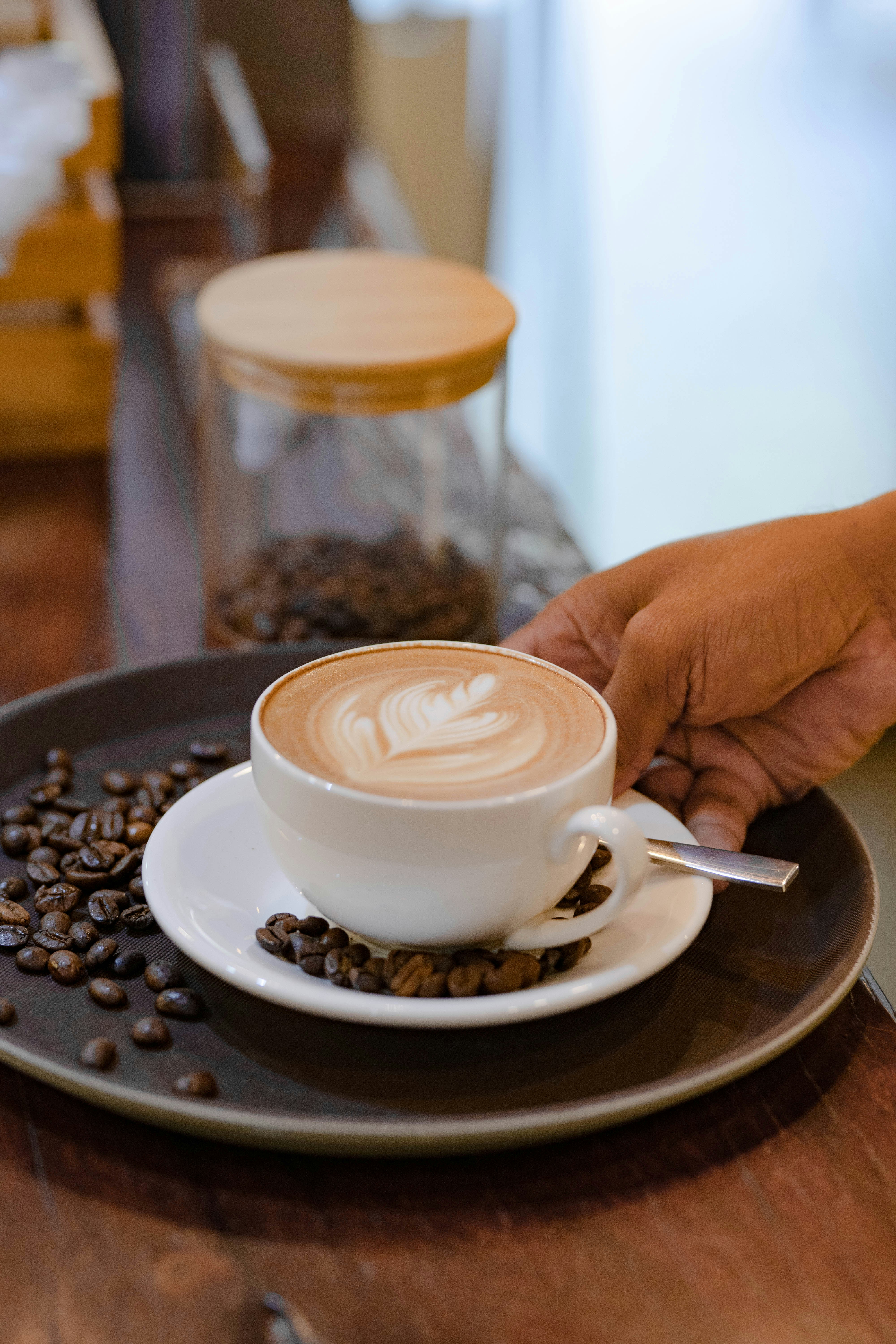 Heart of the Crema: A Hand Reaches for Latte on a Rustic Counter