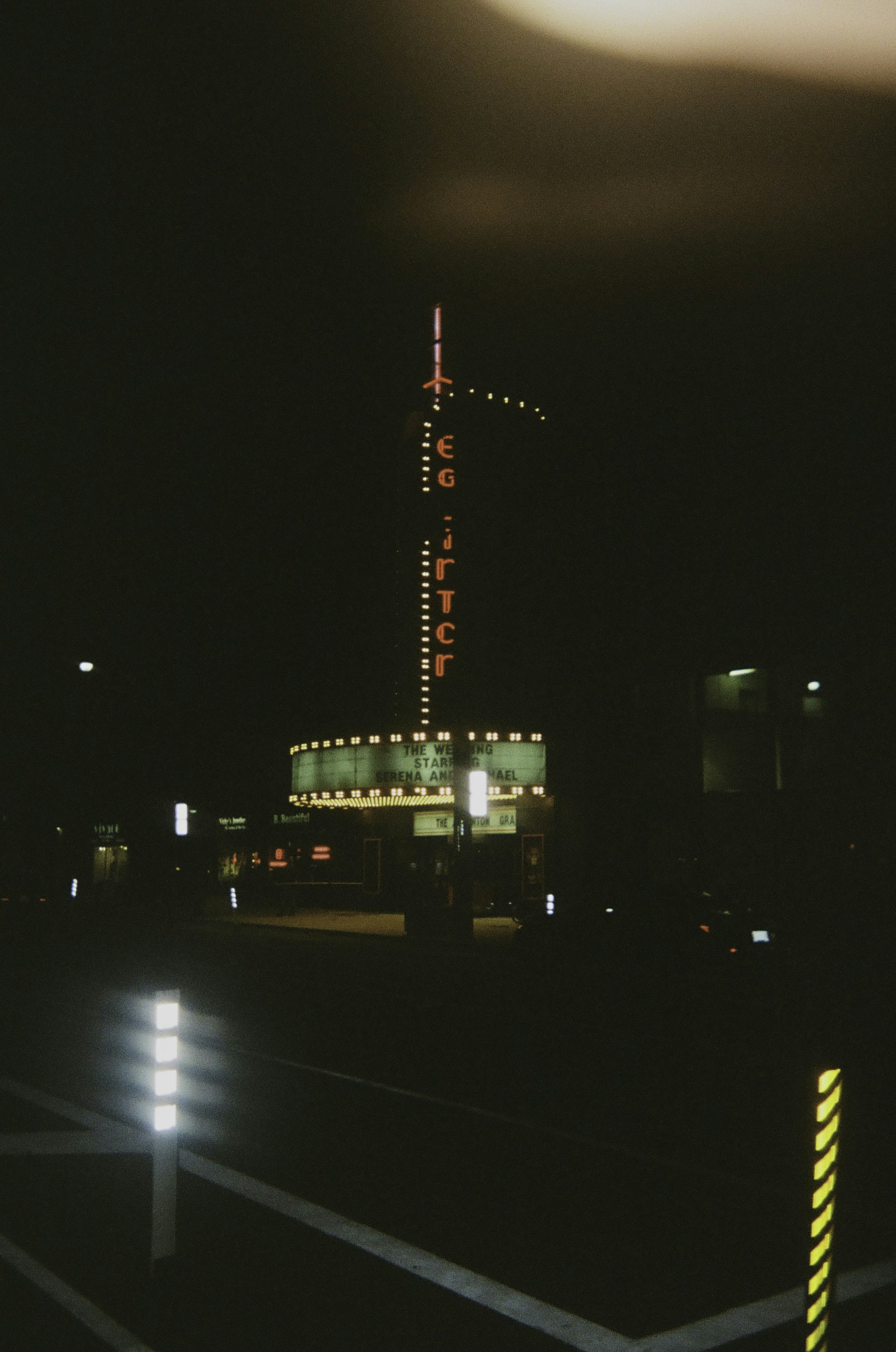 A lit-up sign dominates a nighttime scene. photo – Free Street ...