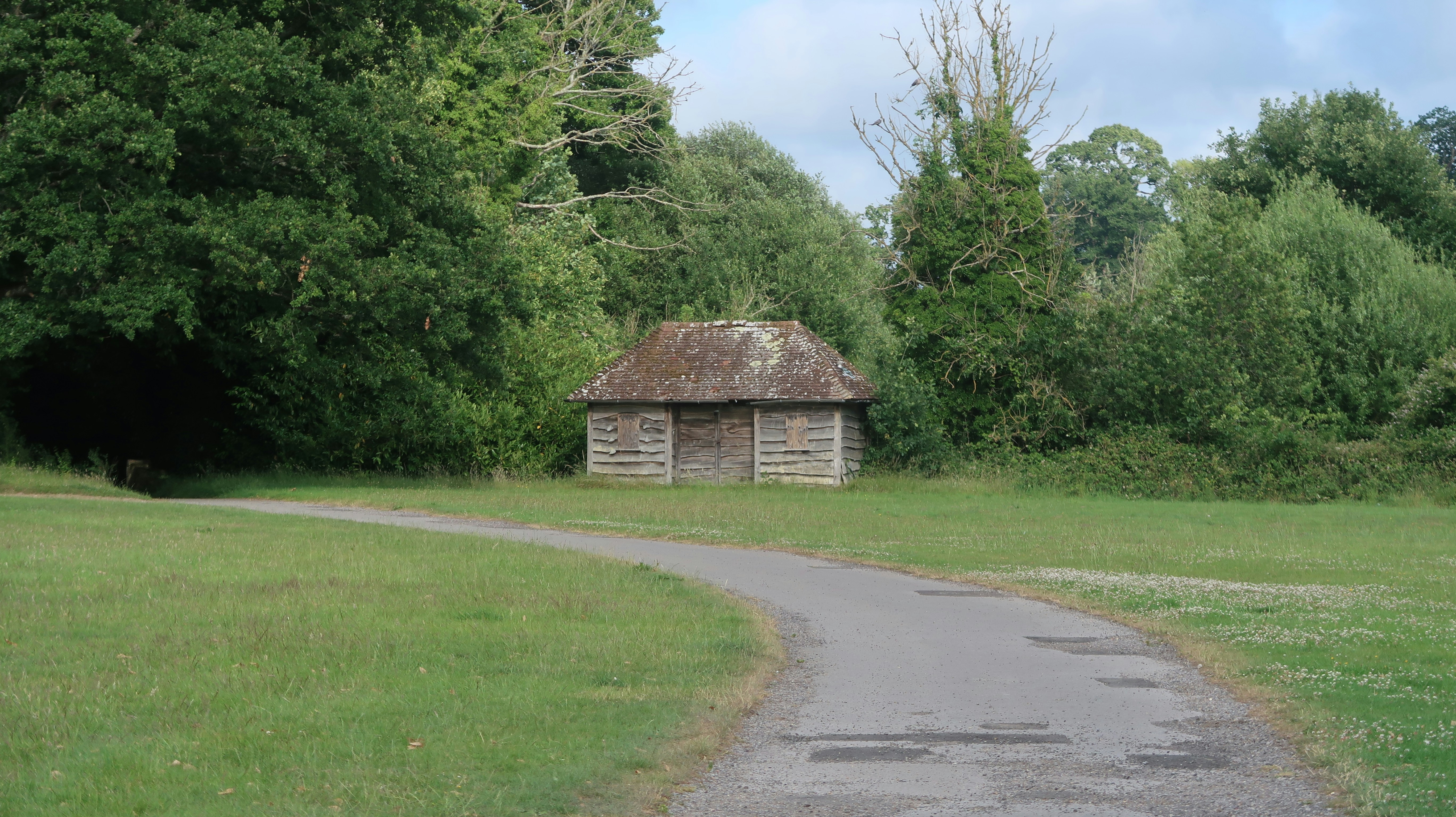 A gravel path leads to a small wooden building.