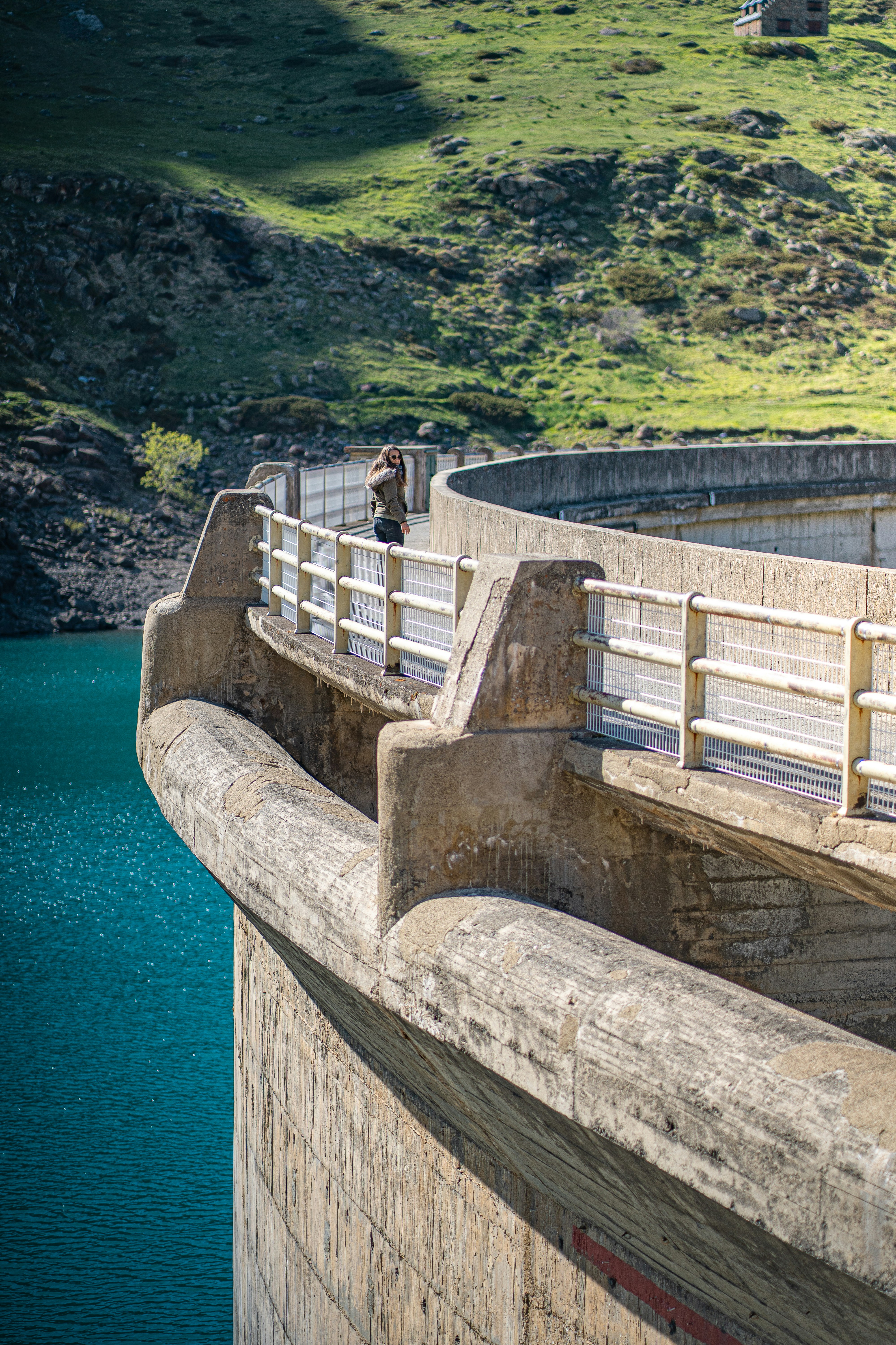 Footpath at the Edge: A Lone Photographer on the Curved Dam