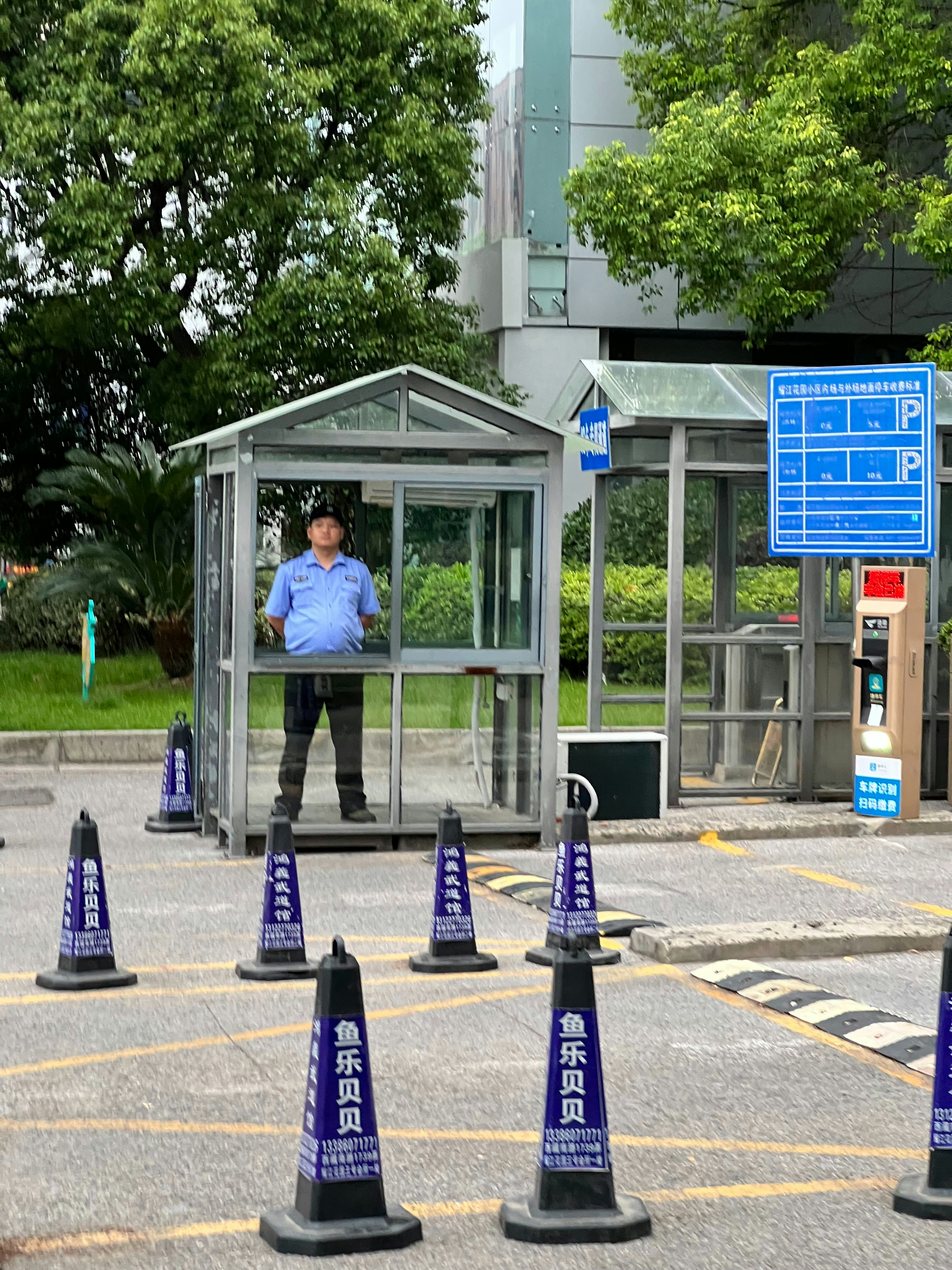 A security guard stands in a glass booth. photo – Free Man Image on ...