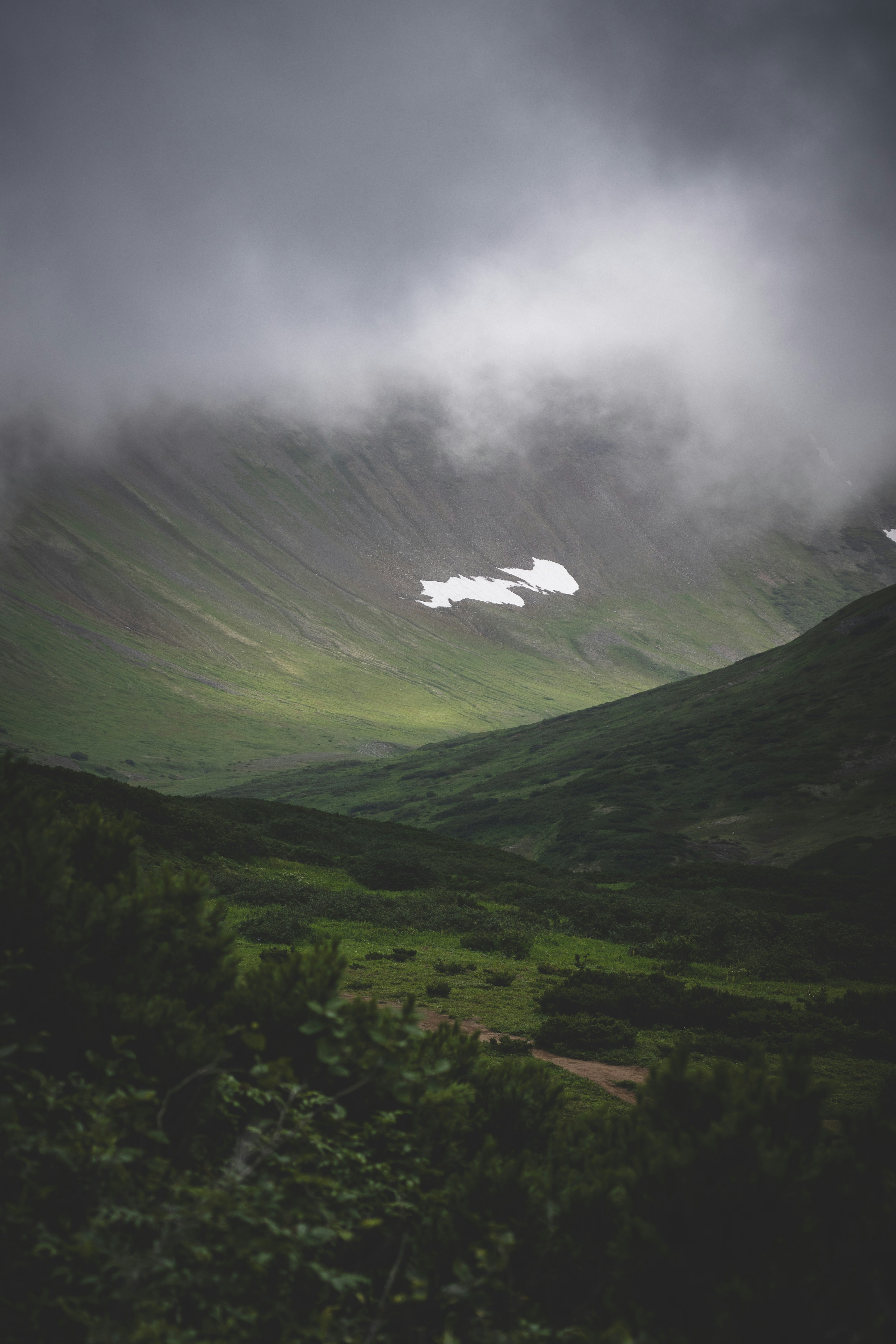 Emerald Valleys Under Whispering Clouds