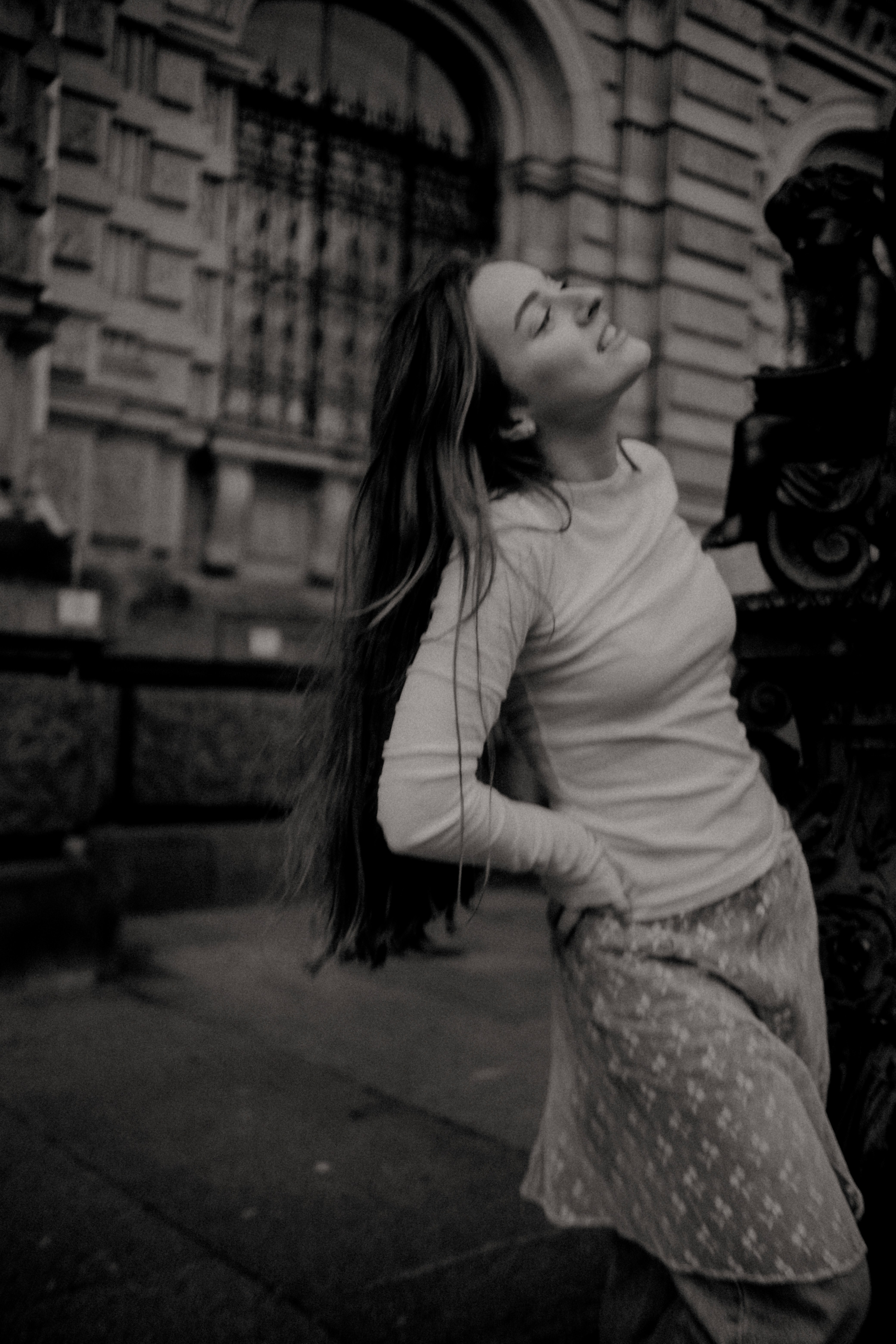 Urban Grayscale: A Joyful Pose by a City Sculpture Corner