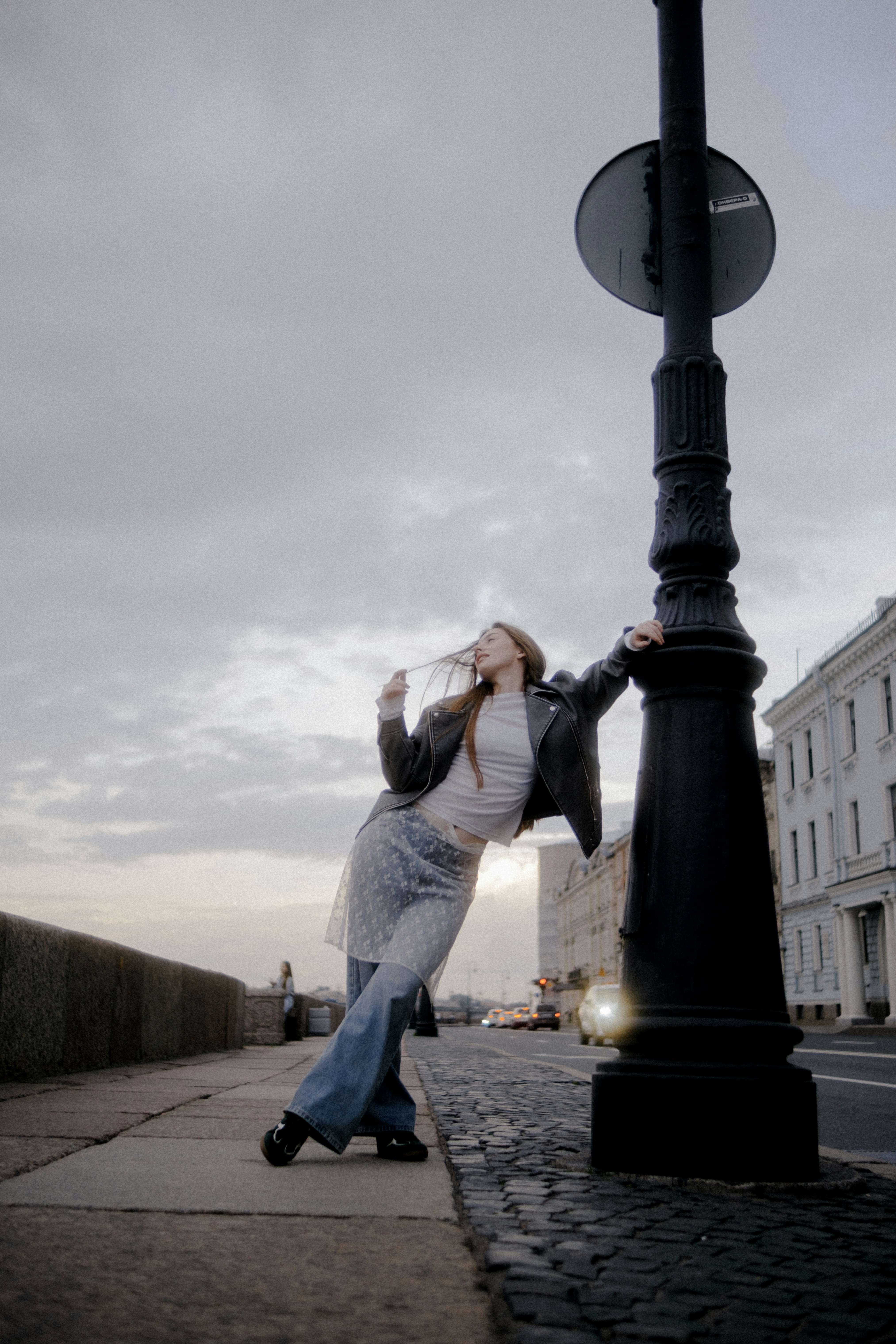 Femme appuyée sur un lampadaire dans une rue de la ville photo – Image ...
