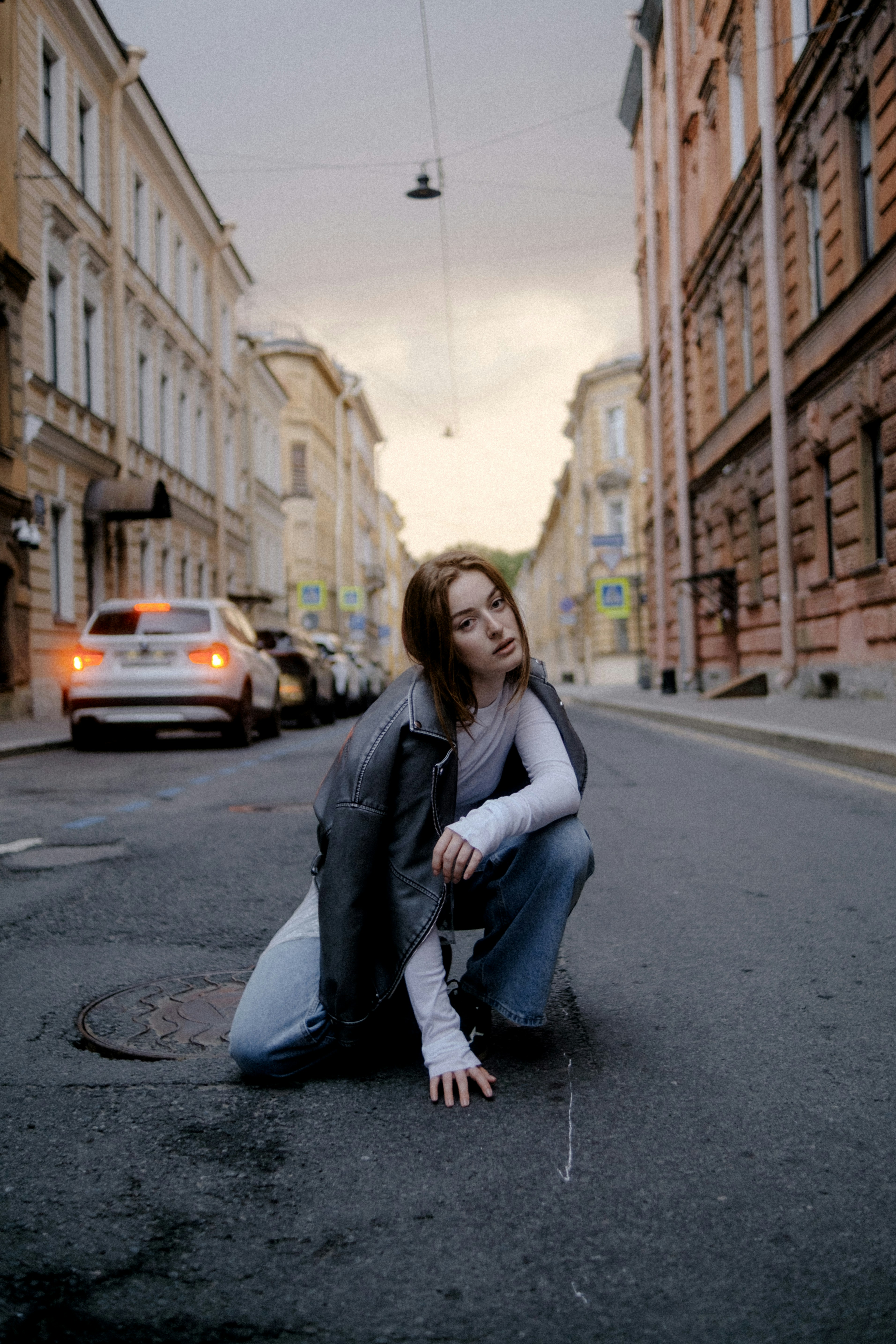 Midstreet Gaze: A Crouched Portrait in Dusk-Soft Urban Light