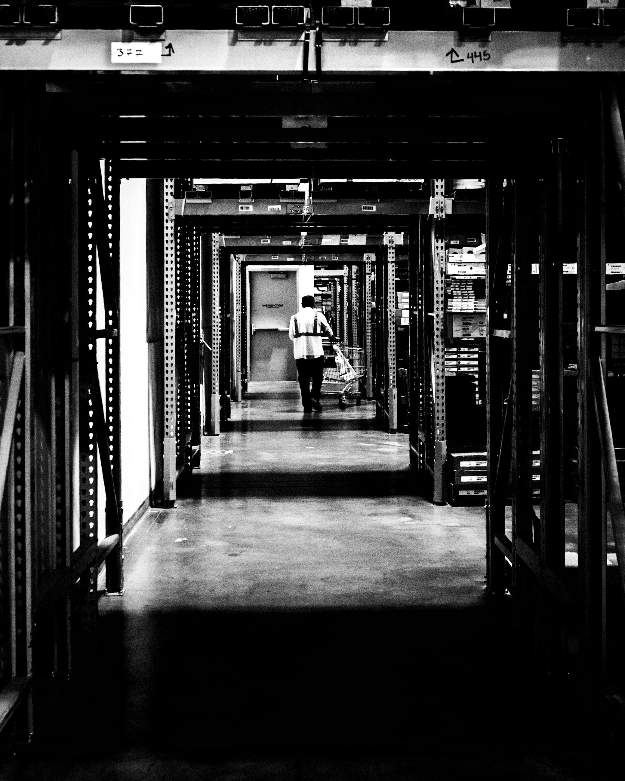 A person walks through a warehouse aisle.