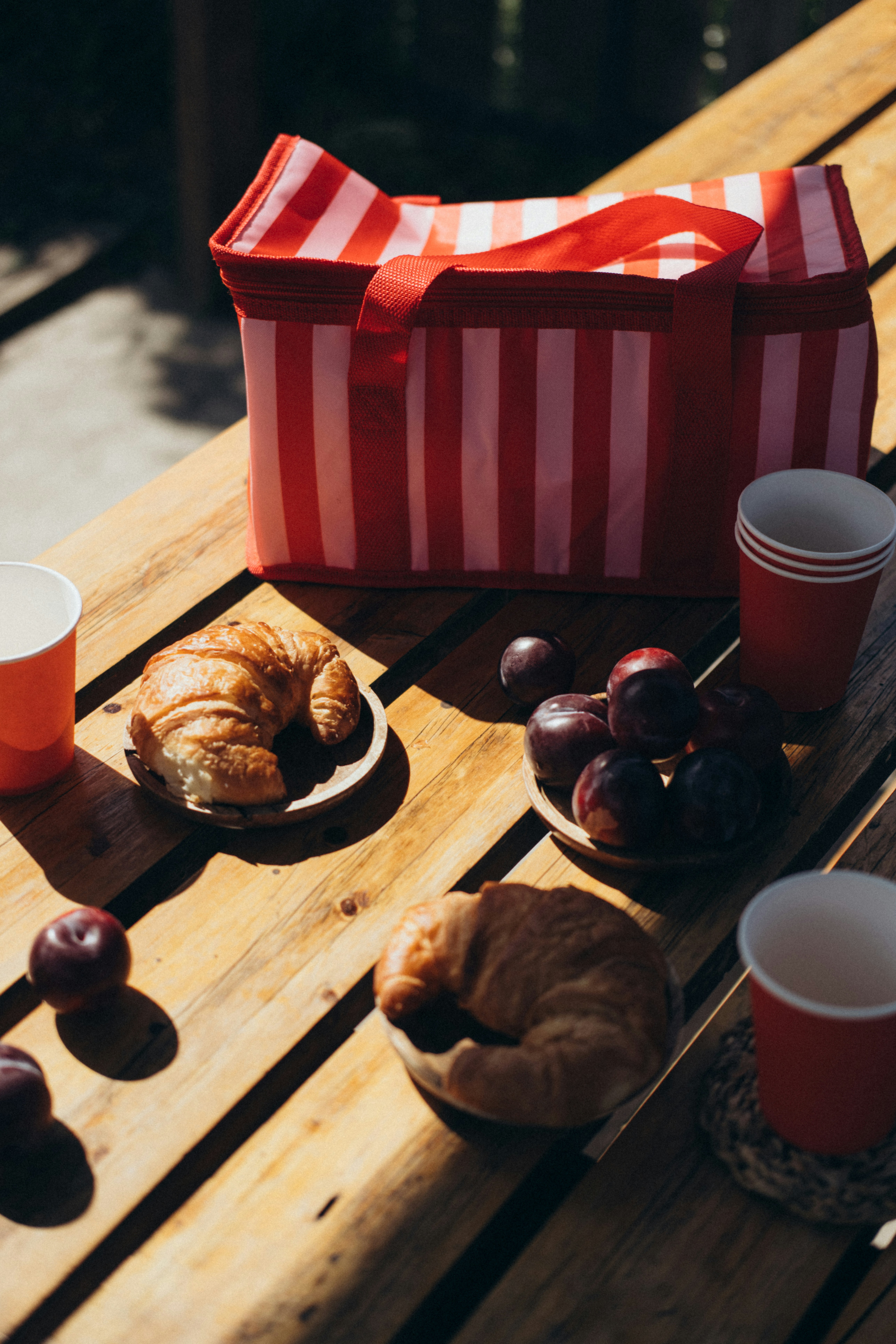 Picnic scene on a wooden table with food.