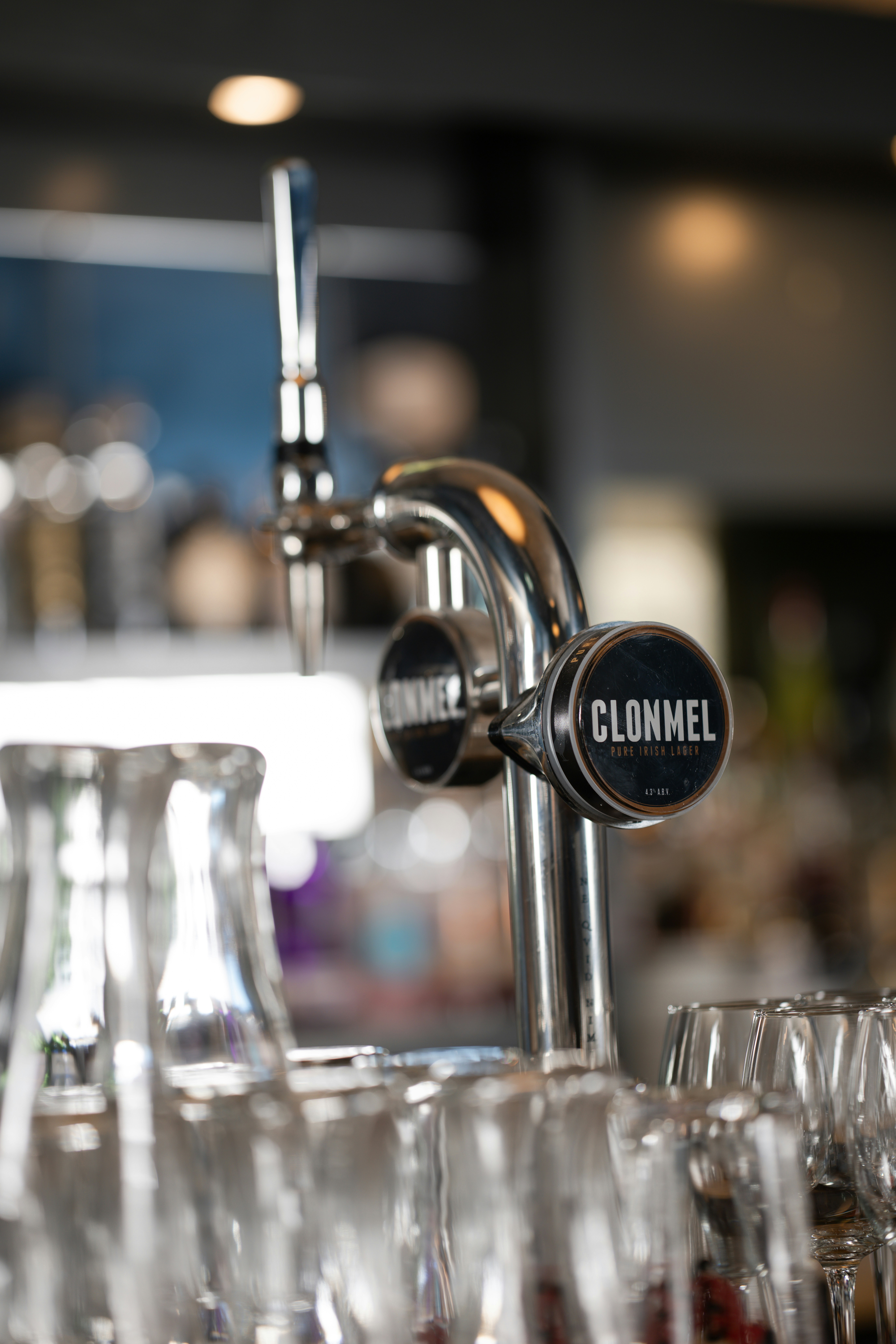 Chrome Tap Knob with CLONMEL Logo Anchors a Quiet Bar Scene