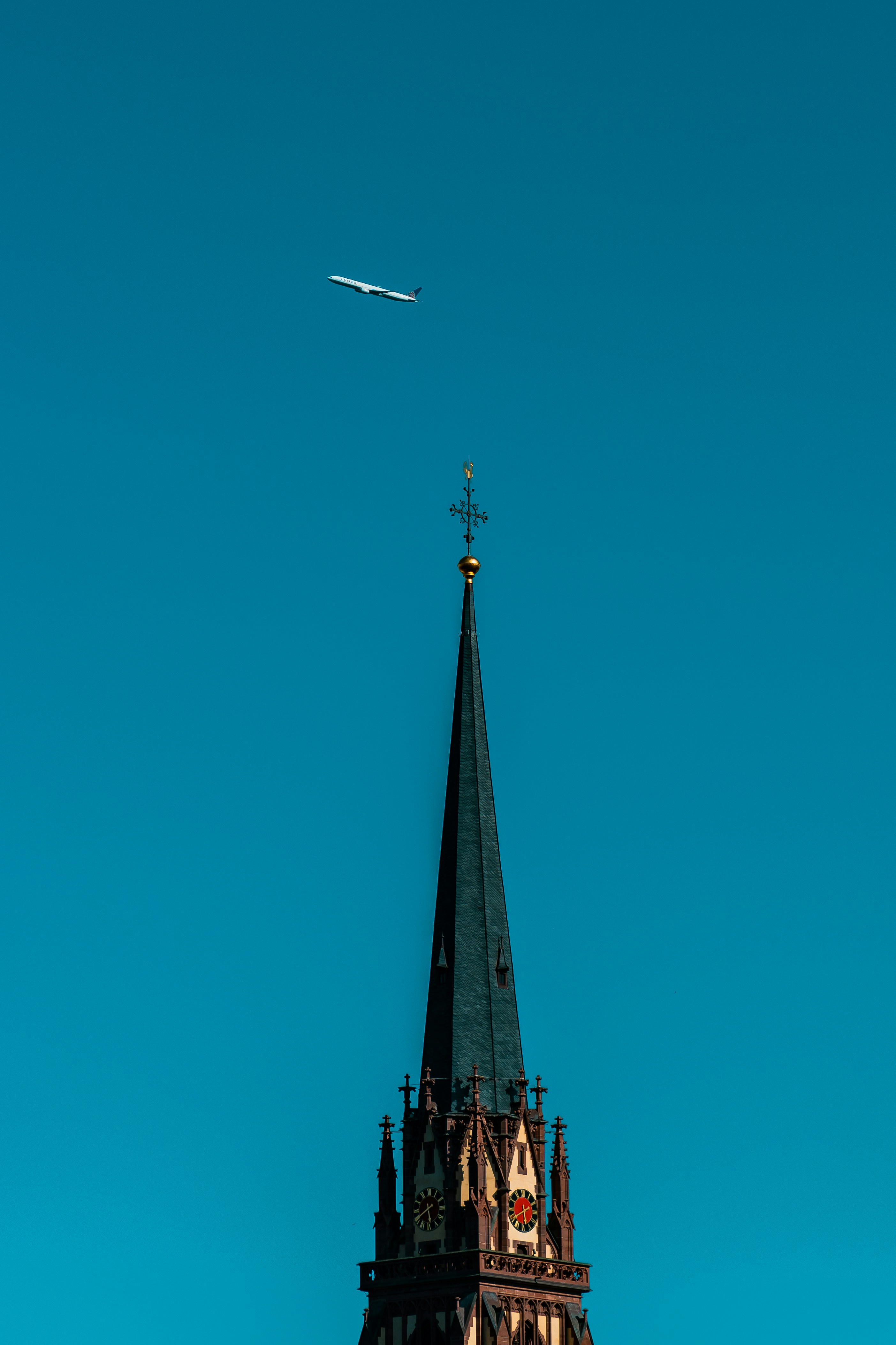 A church spire reaches up to a clear blue sky.
