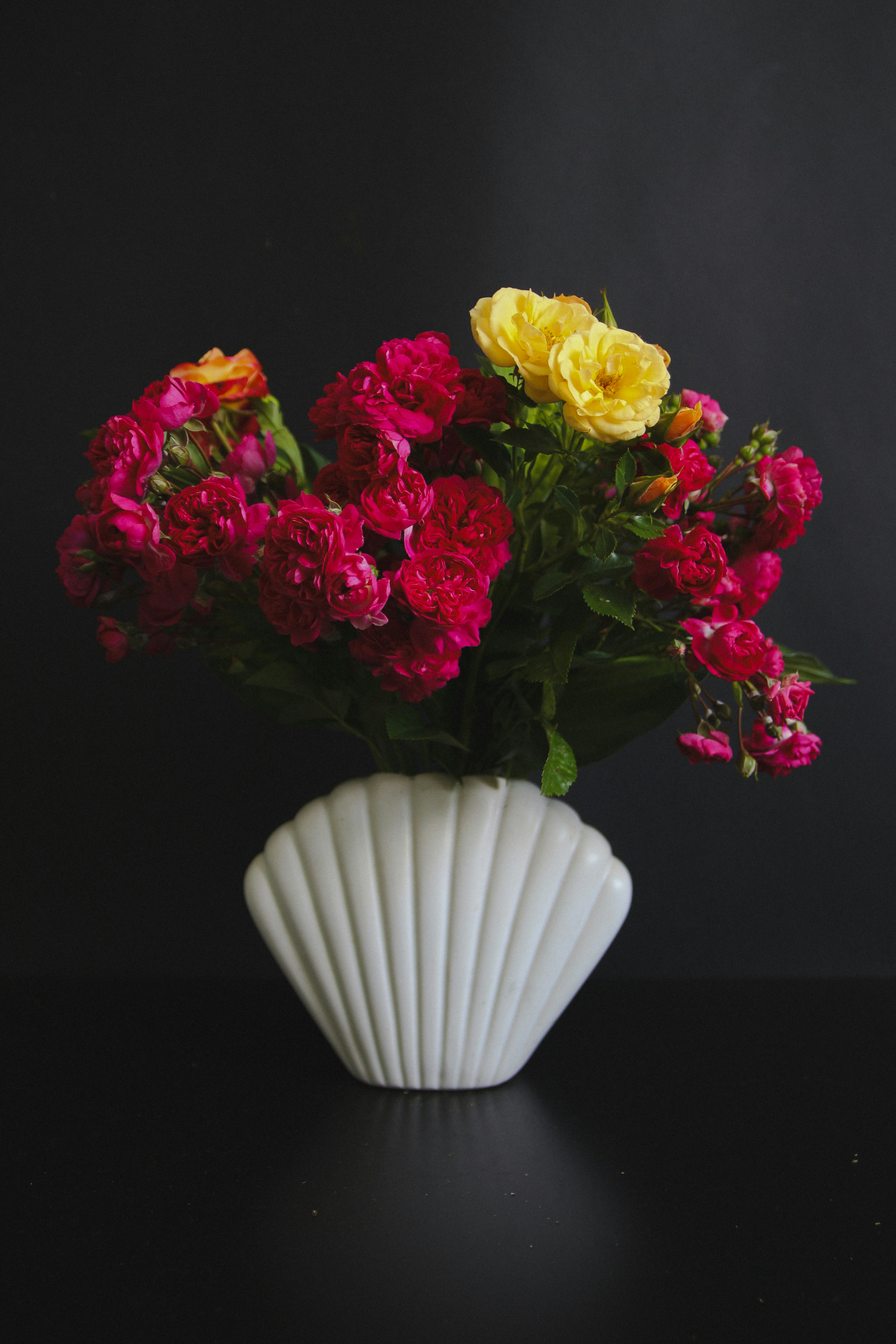 Crimson, Pink, and Canary Roses in a Ribbed White Vase
