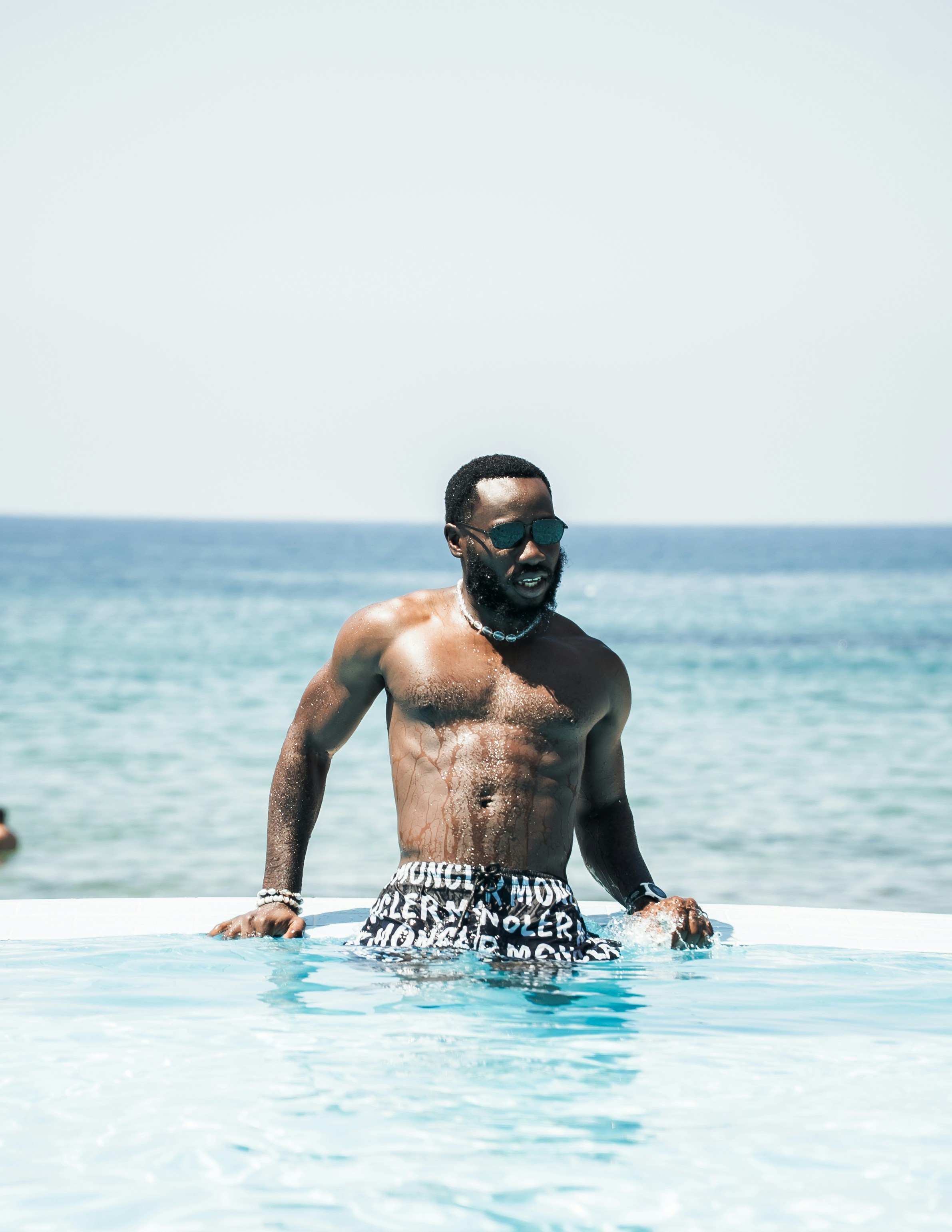 Sunlit Confidence: A Man in the Pool by the Sea
