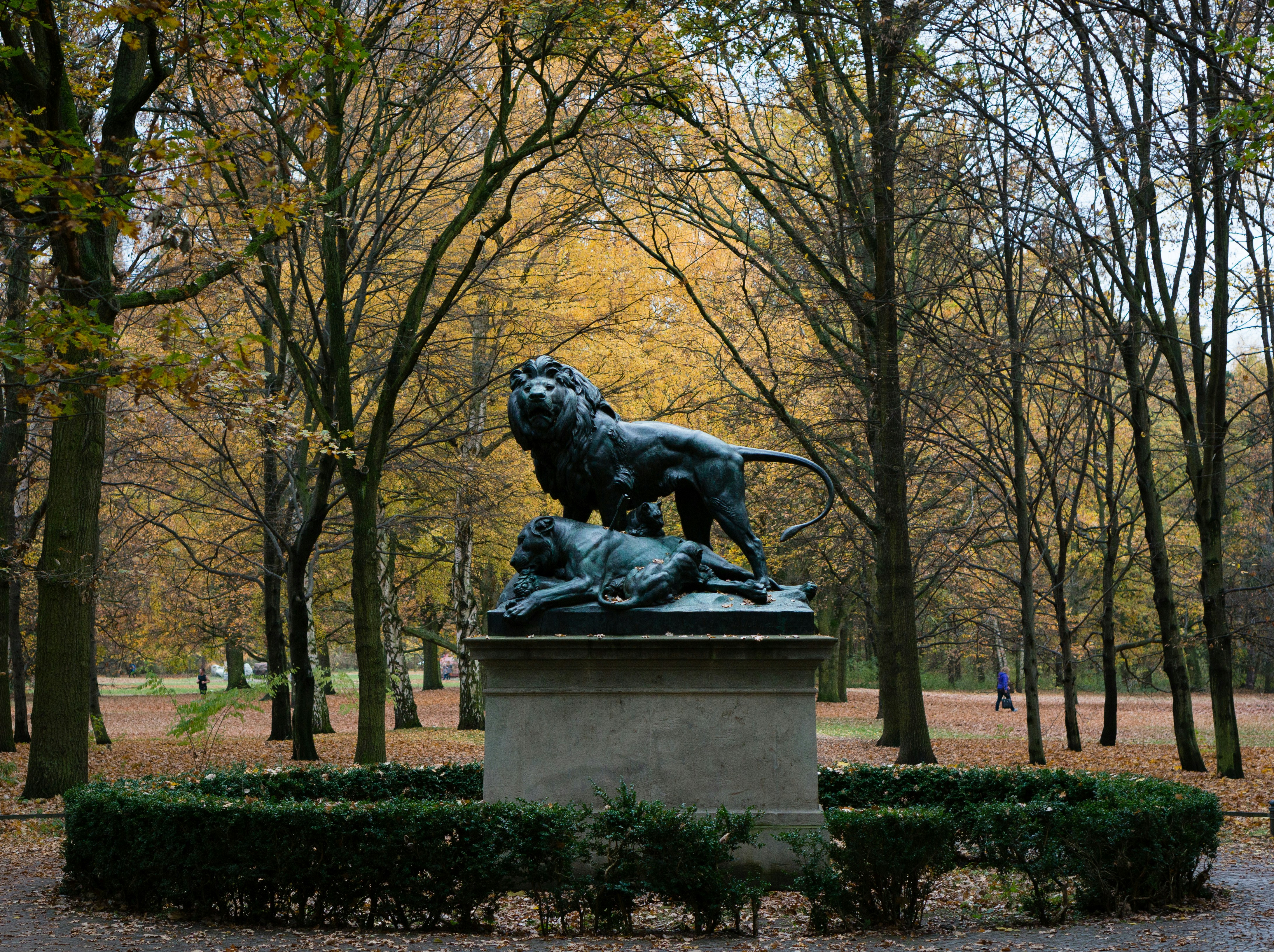 A lion statue stands proudly in the autumn park.