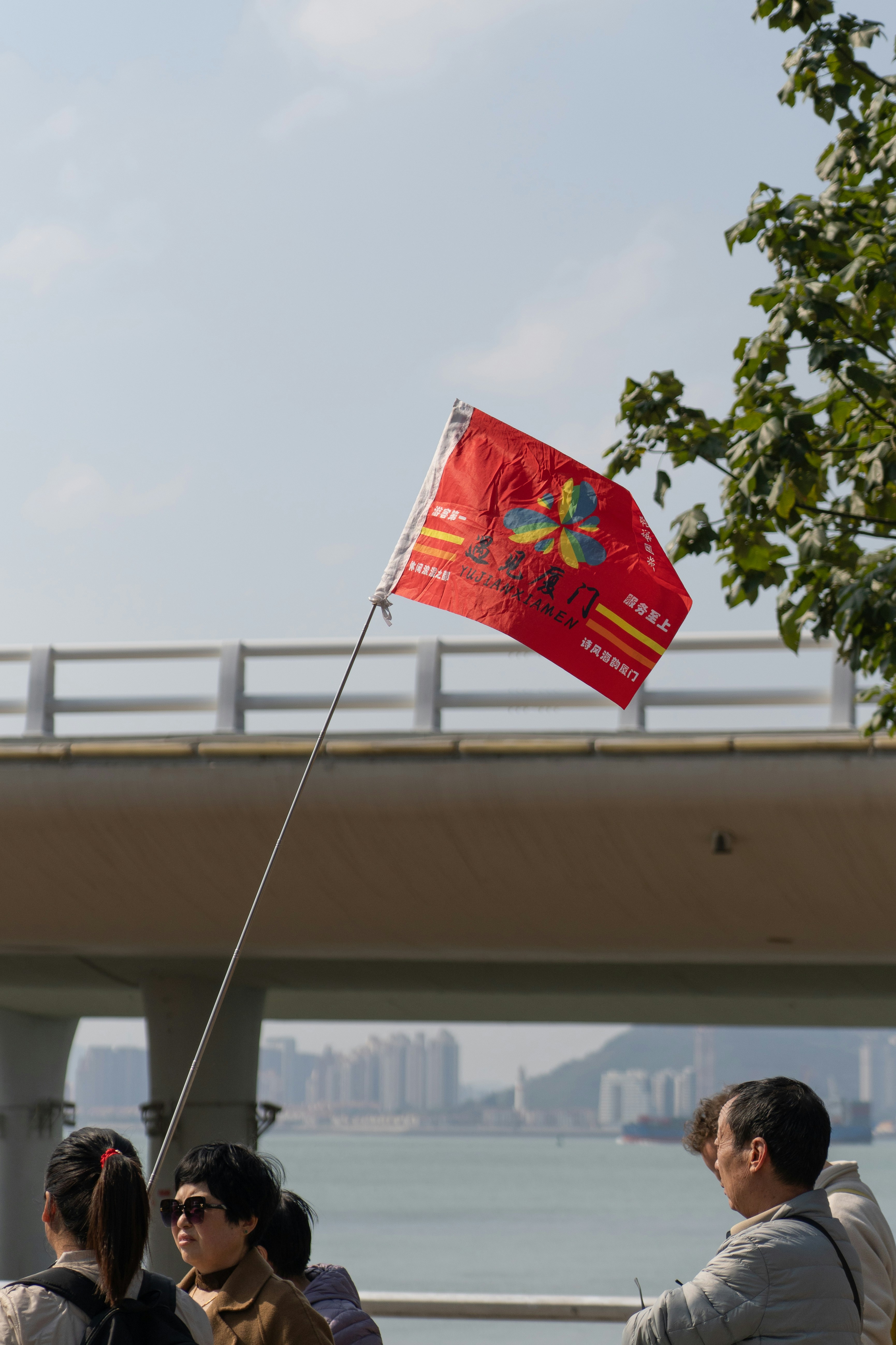 A red flag waves in front of a bridge. photo – Free Woman Image on Unsplash