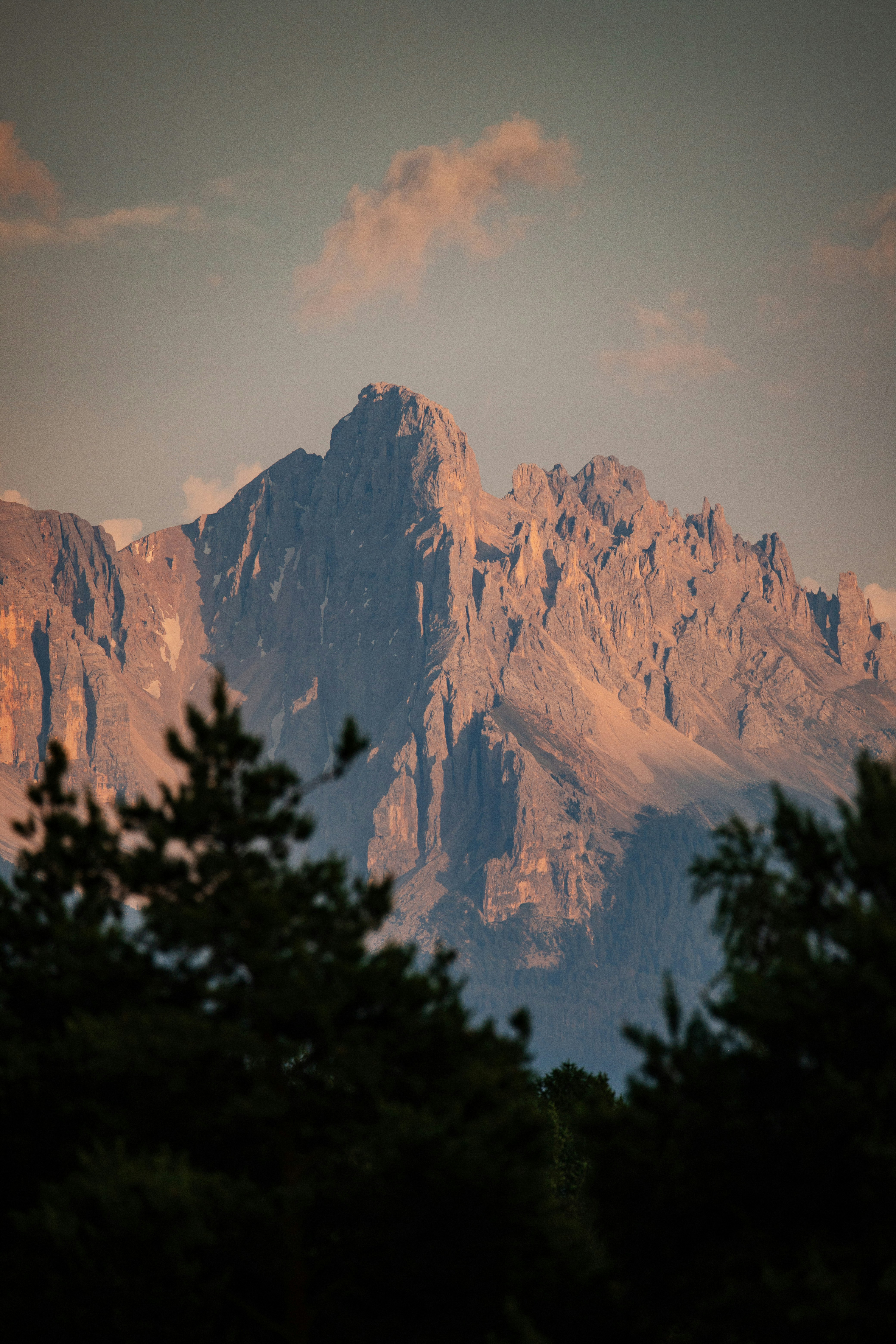 Majestätische Berggipfel erheben sich hinter dunklen Bäumen. Foto ...