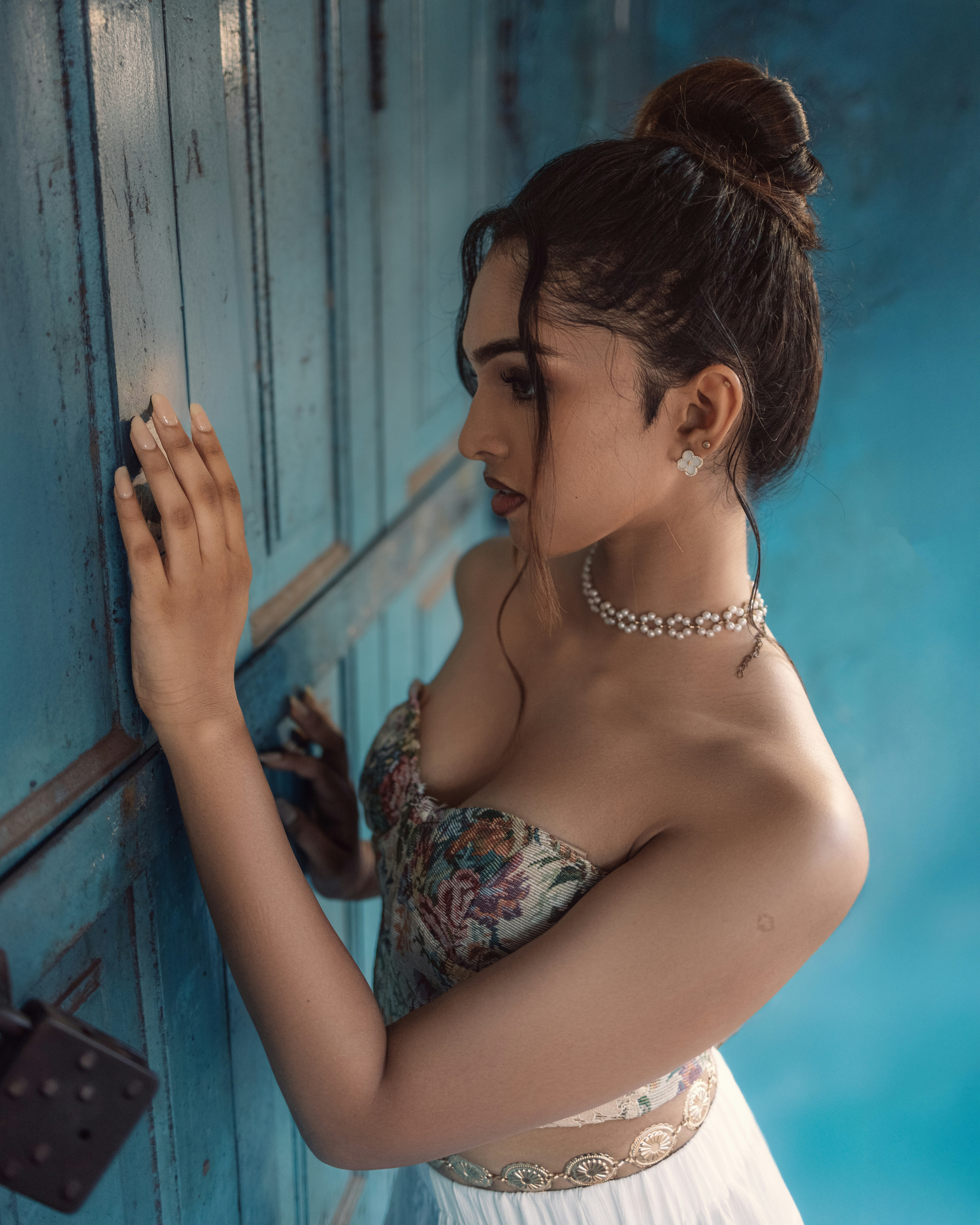 Beautiful woman poses beside a blue door.