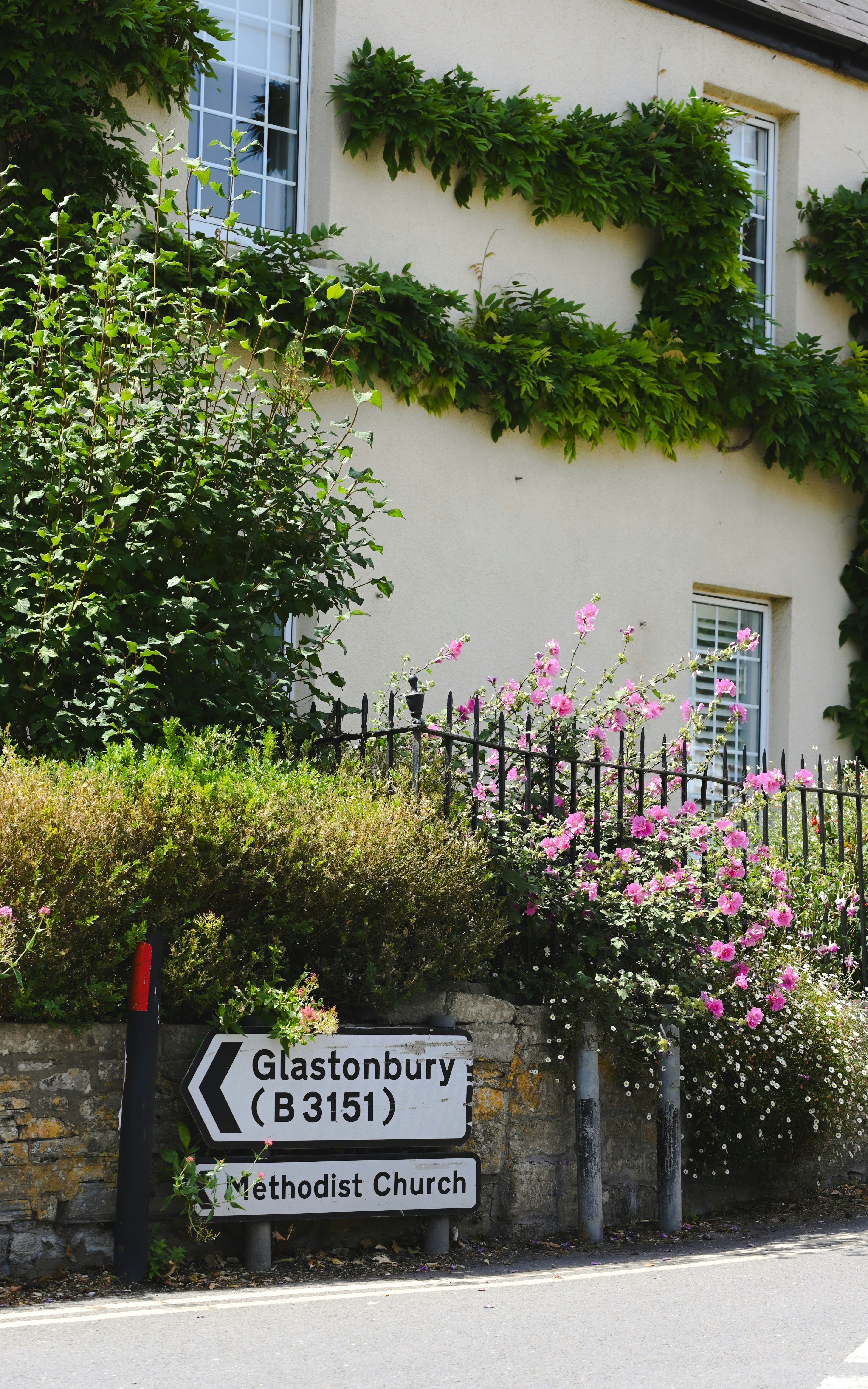 To Glasto! | A sign points to glastonbury near a church.