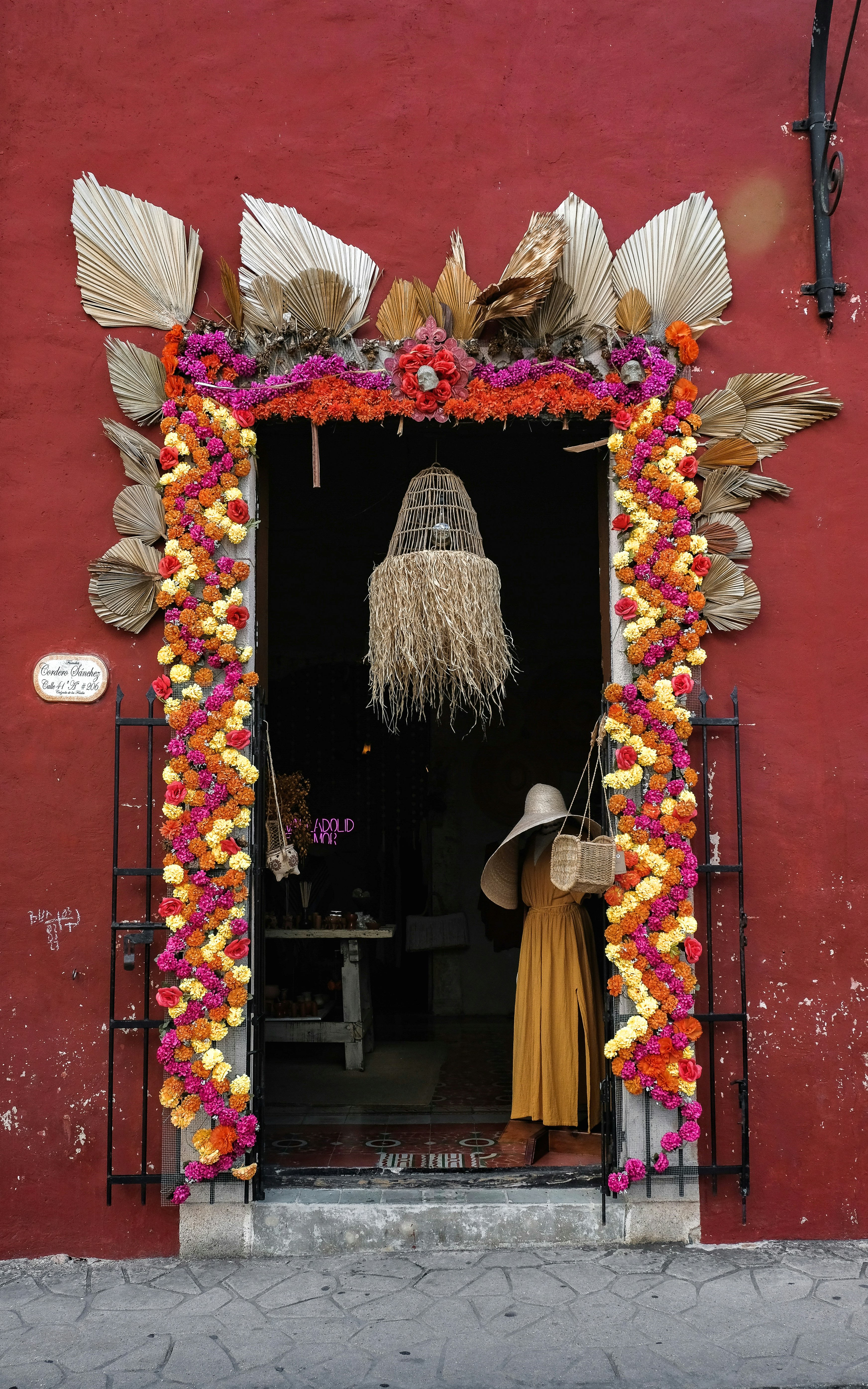 Red Doorway Framed by Floral Garlands with a Looming Straw Lantern