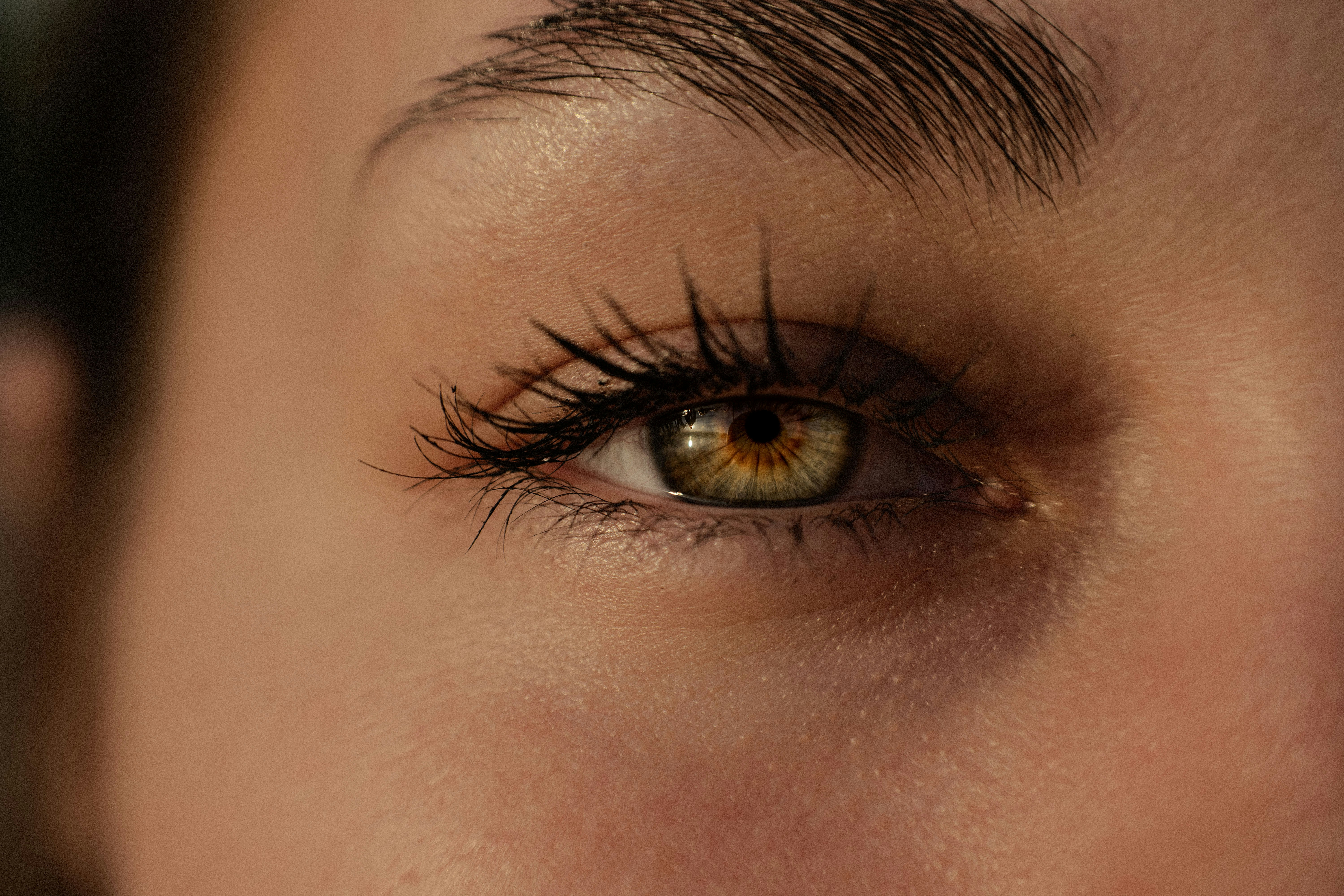Close-up of a green eye with long eyelashes.