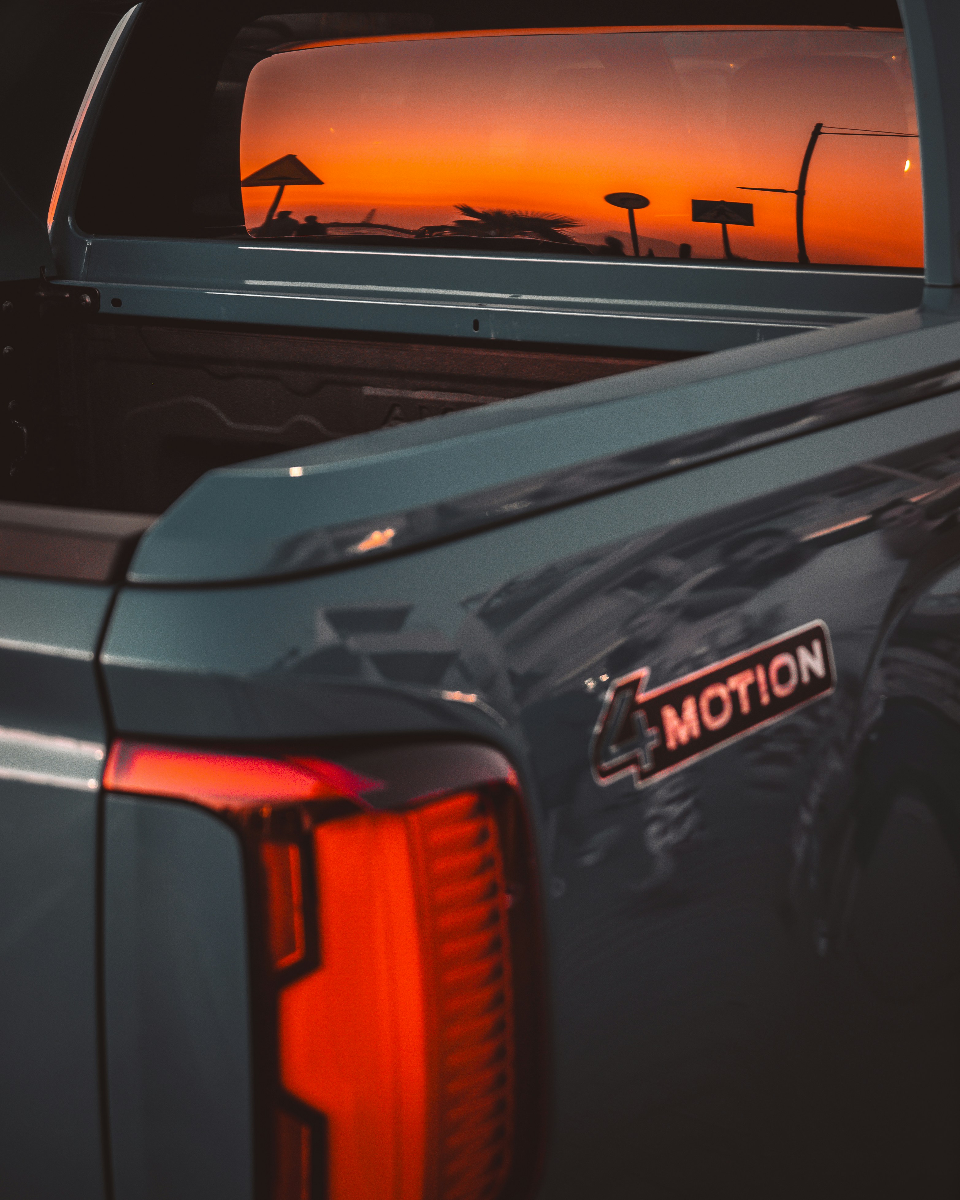 The sunset reflects in the truck's rear window.