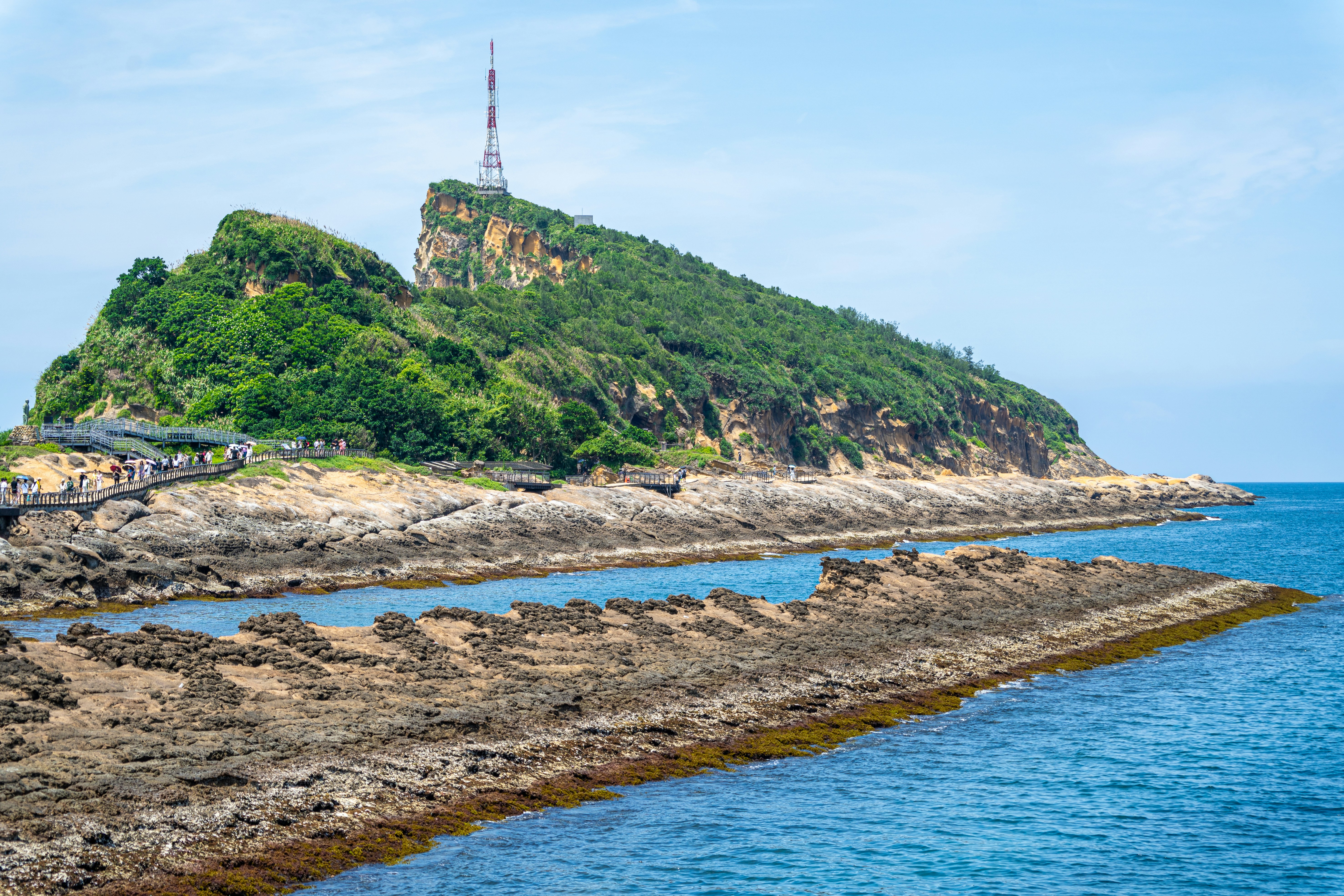 A green hill rises beside the calm ocean. photo – Free Sea Image on ...