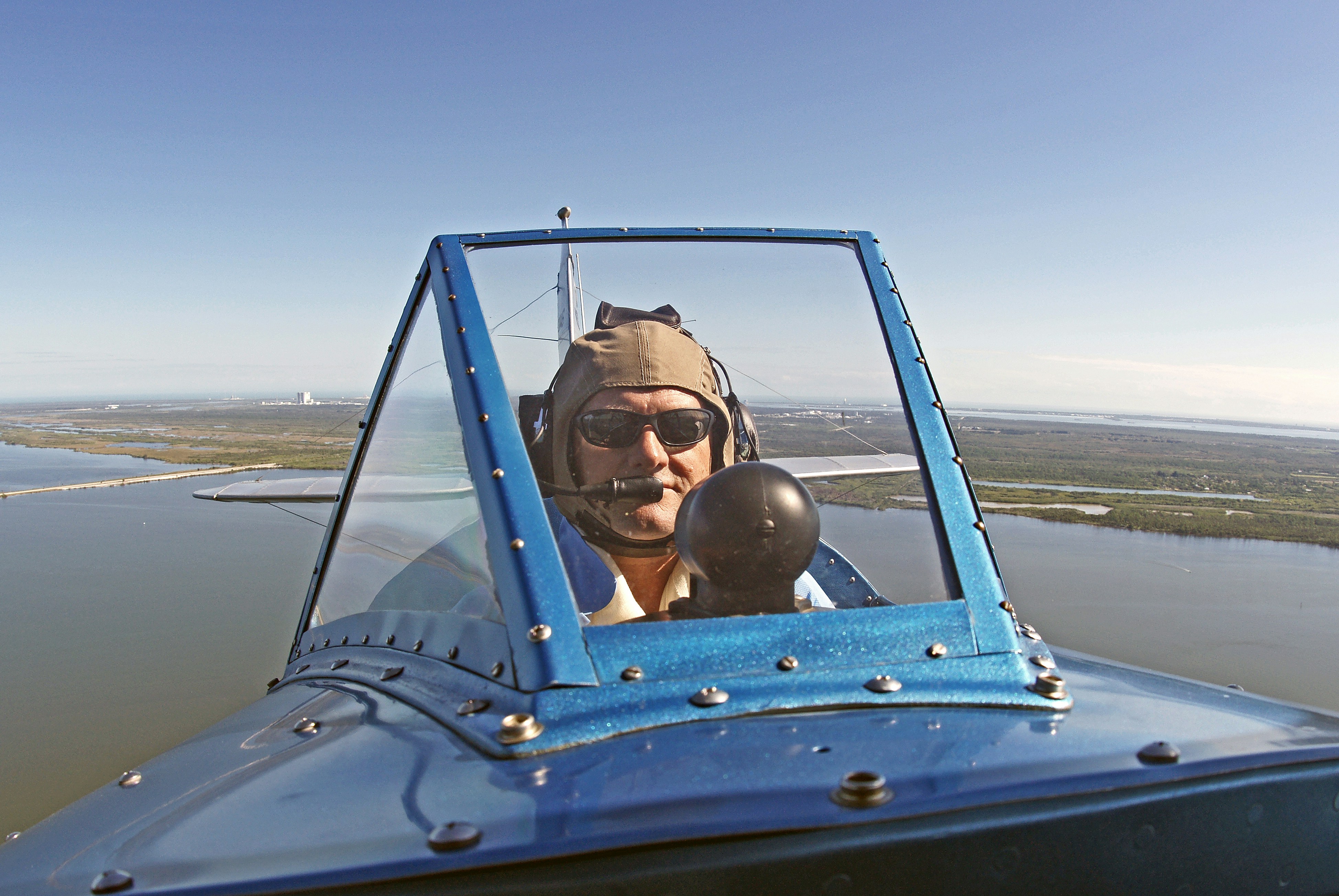 A pilot flies a plane on a sunny day. photo – Free River Image on Unsplash