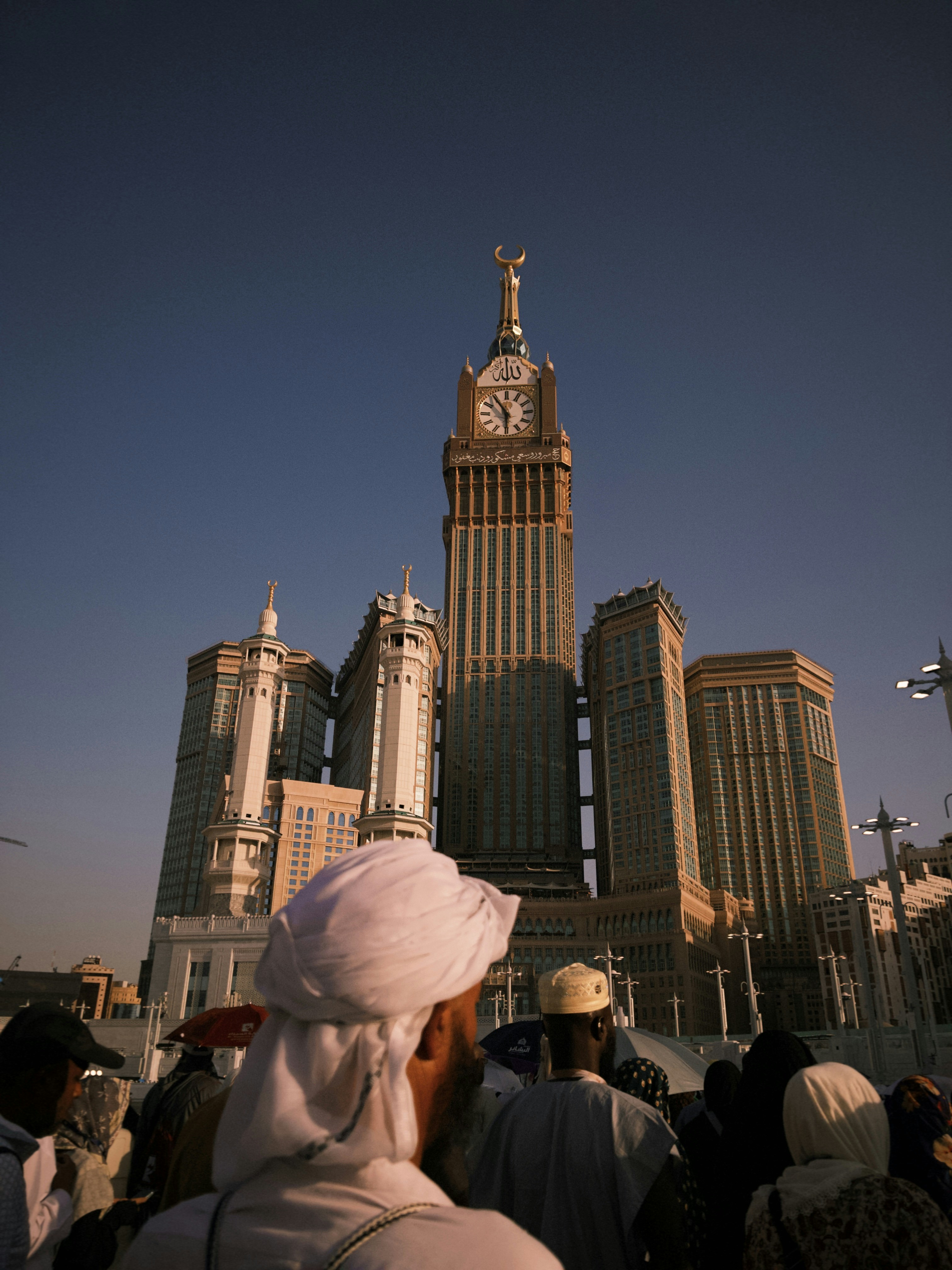 Foto Orang-orang berdiri di depan menara jam abraj al-bait. – Gambar ...