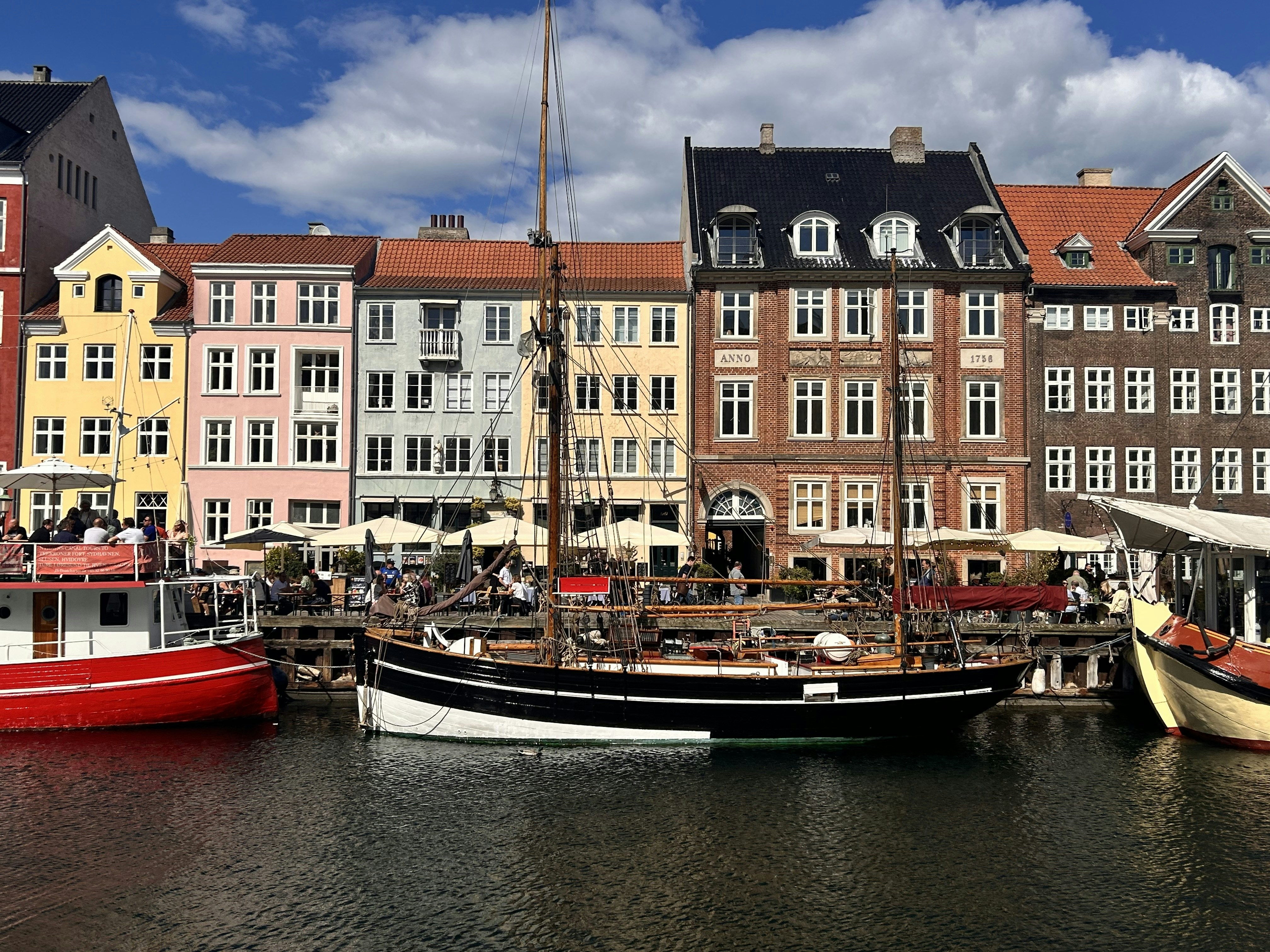 Colorful buildings line a canal with boats.