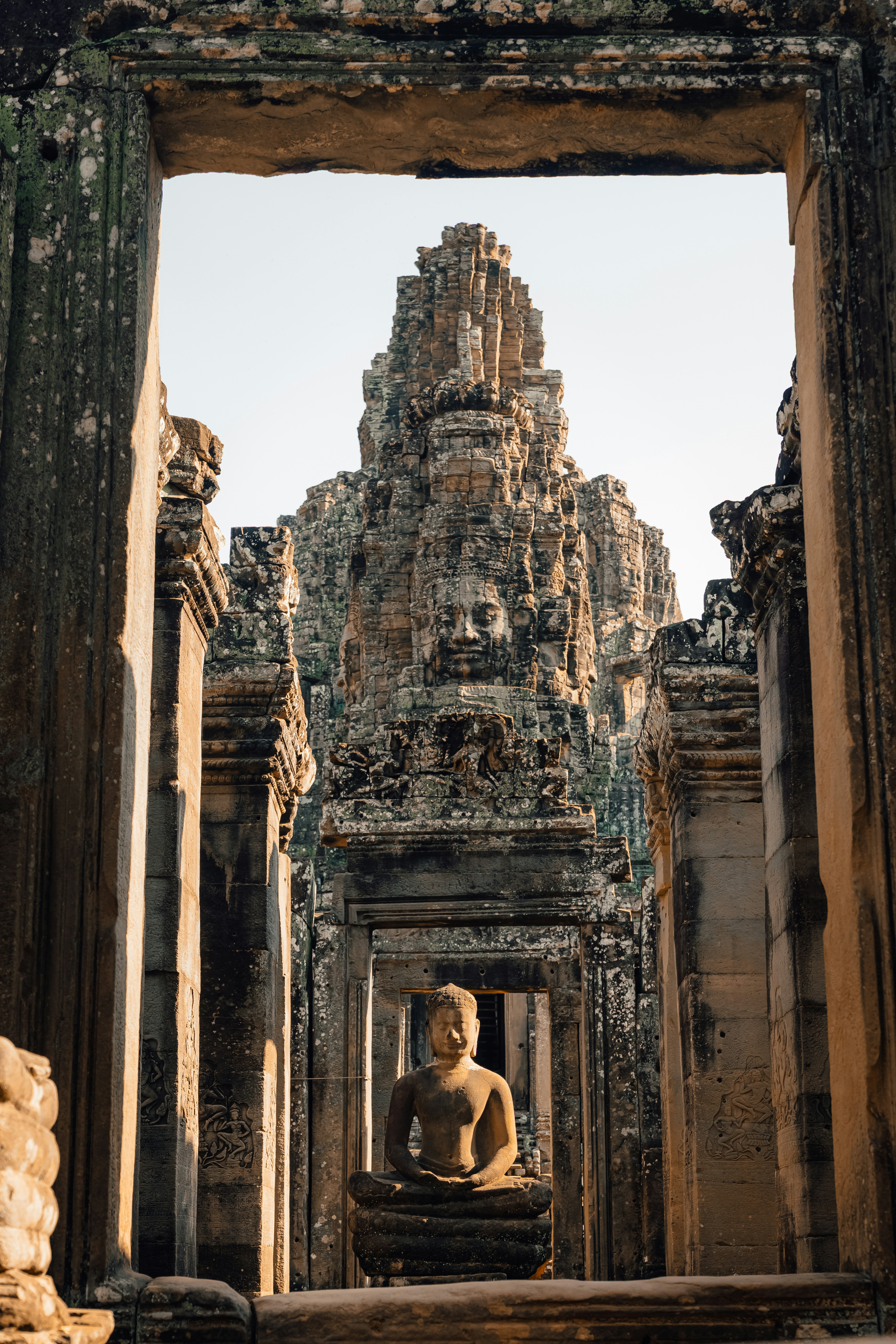 A statue sits framed by an ancient temple.