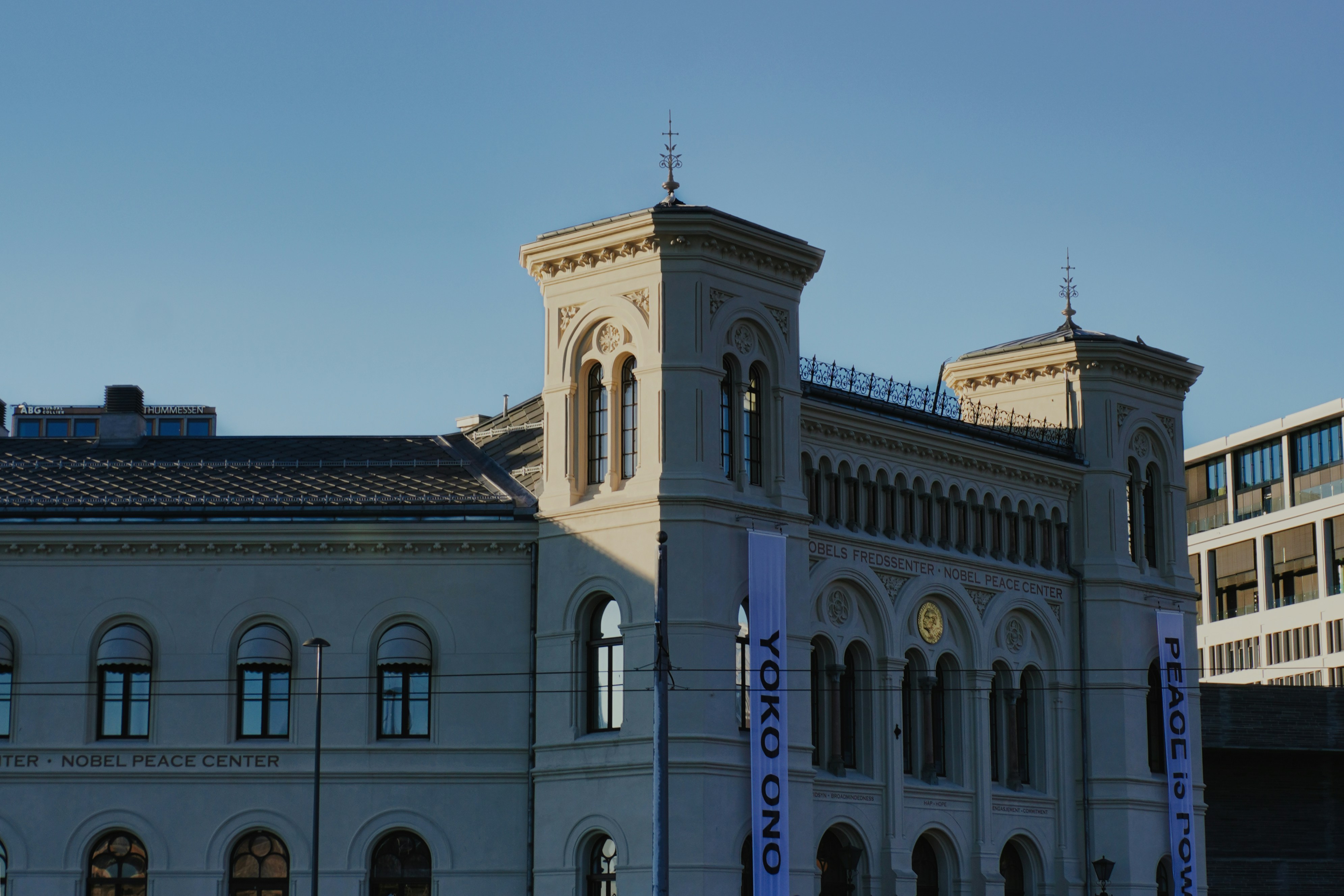 Towered Neoclassical Facade: Blue-Bannered Edifice Under a Clear Sky