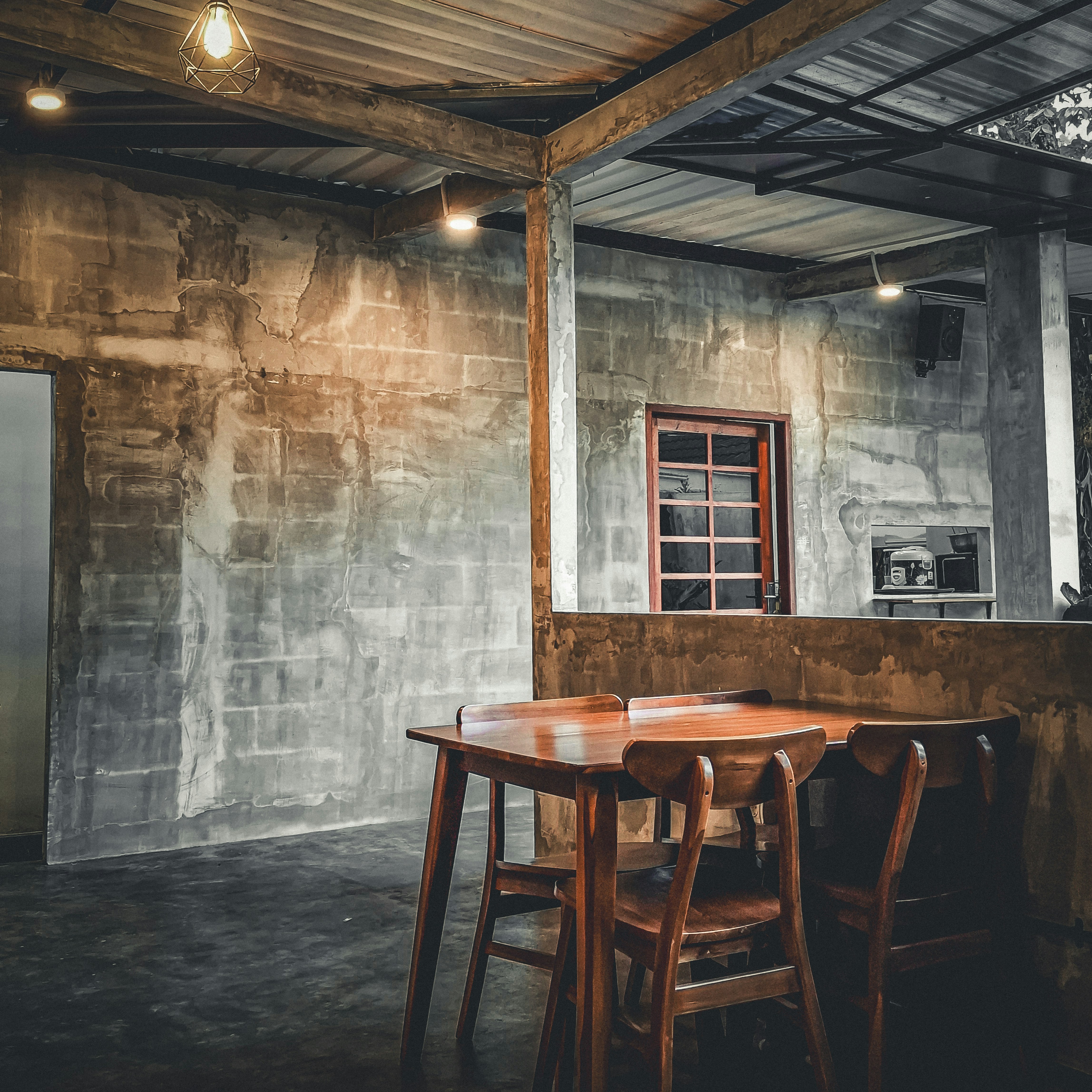 Rustic restaurant with wooden furniture and concrete walls.