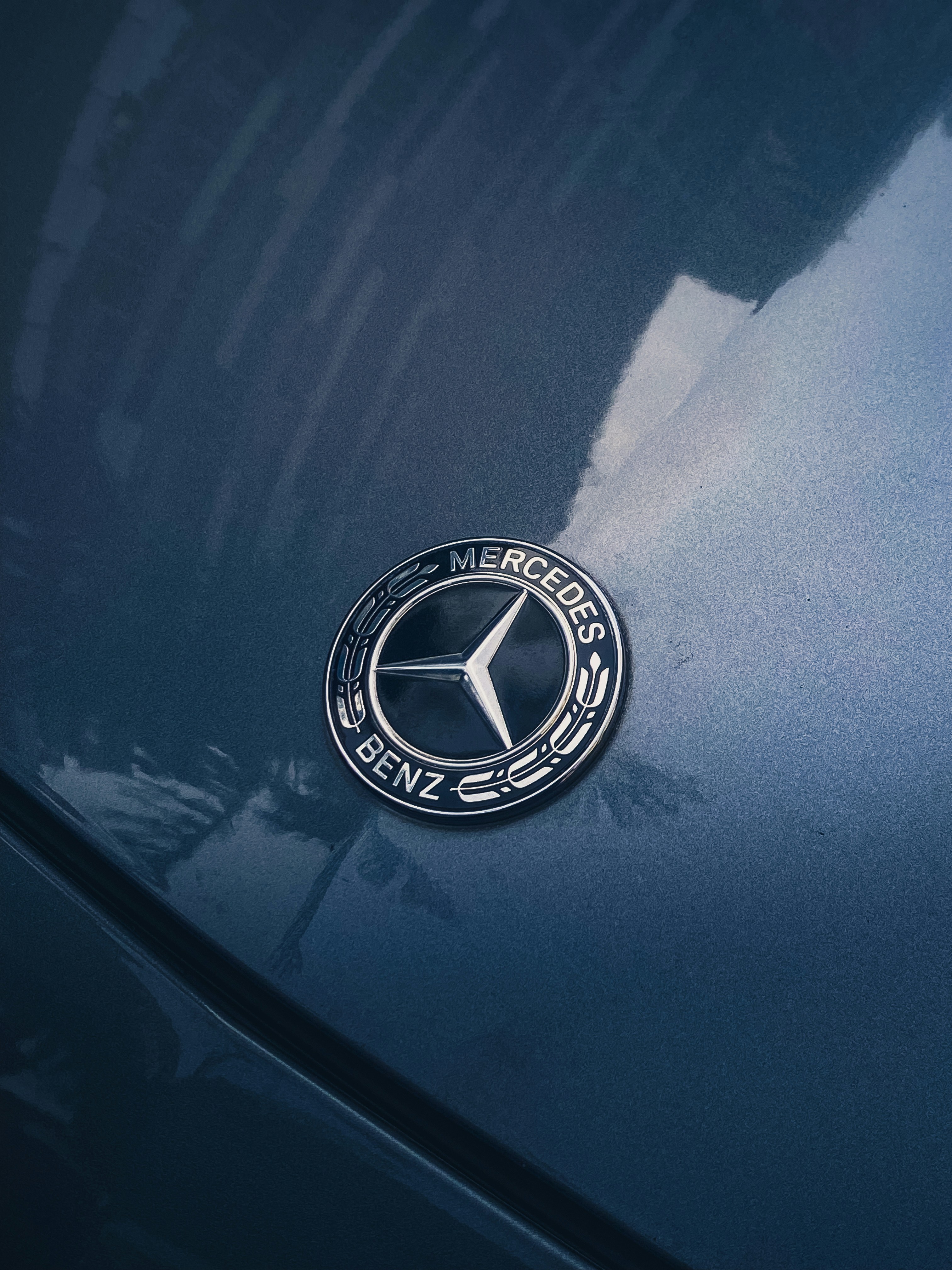 Cerulean Crest: Mercedes-Benz star on a quiet blue metallic panel