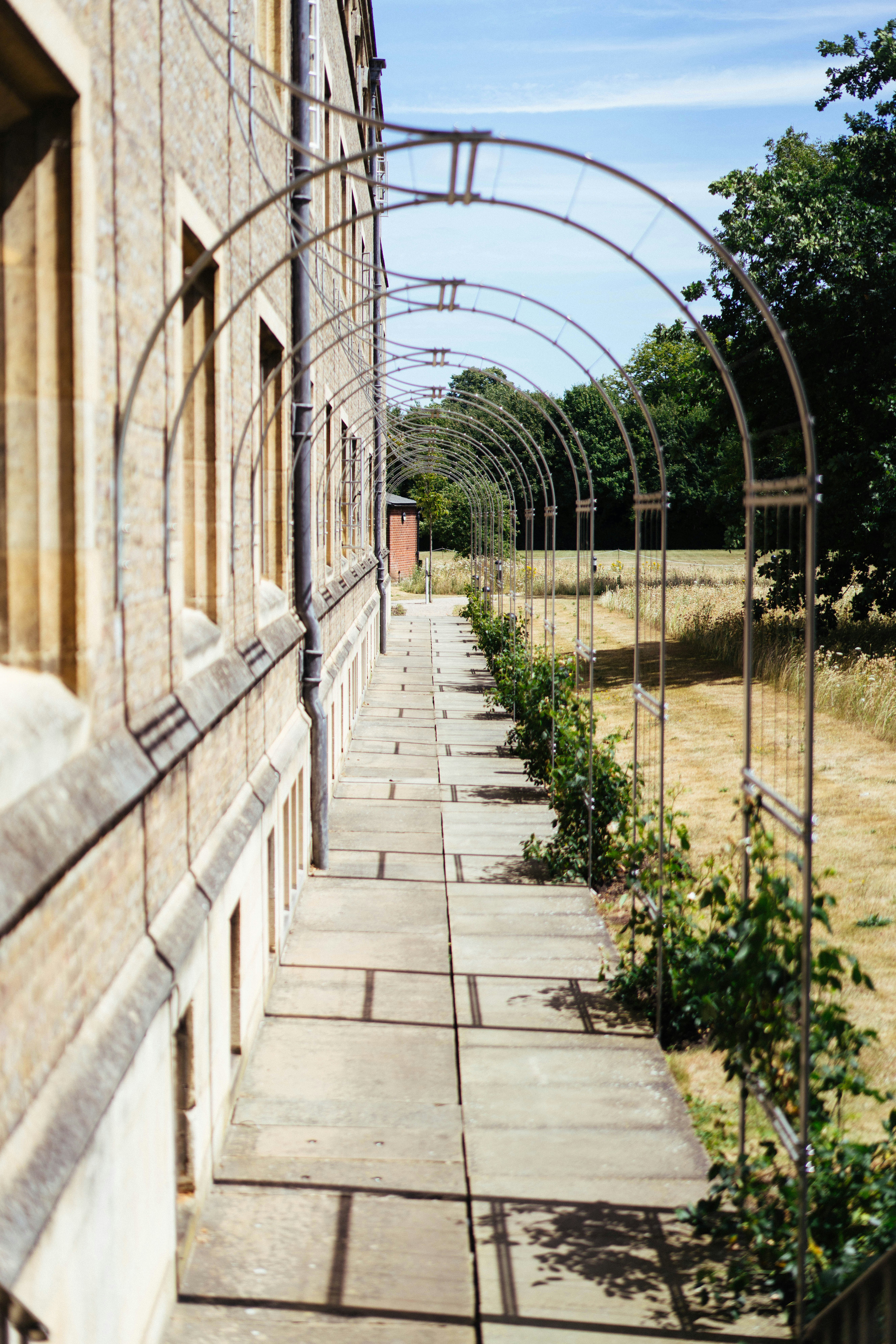 A pathway with arches next to a building.