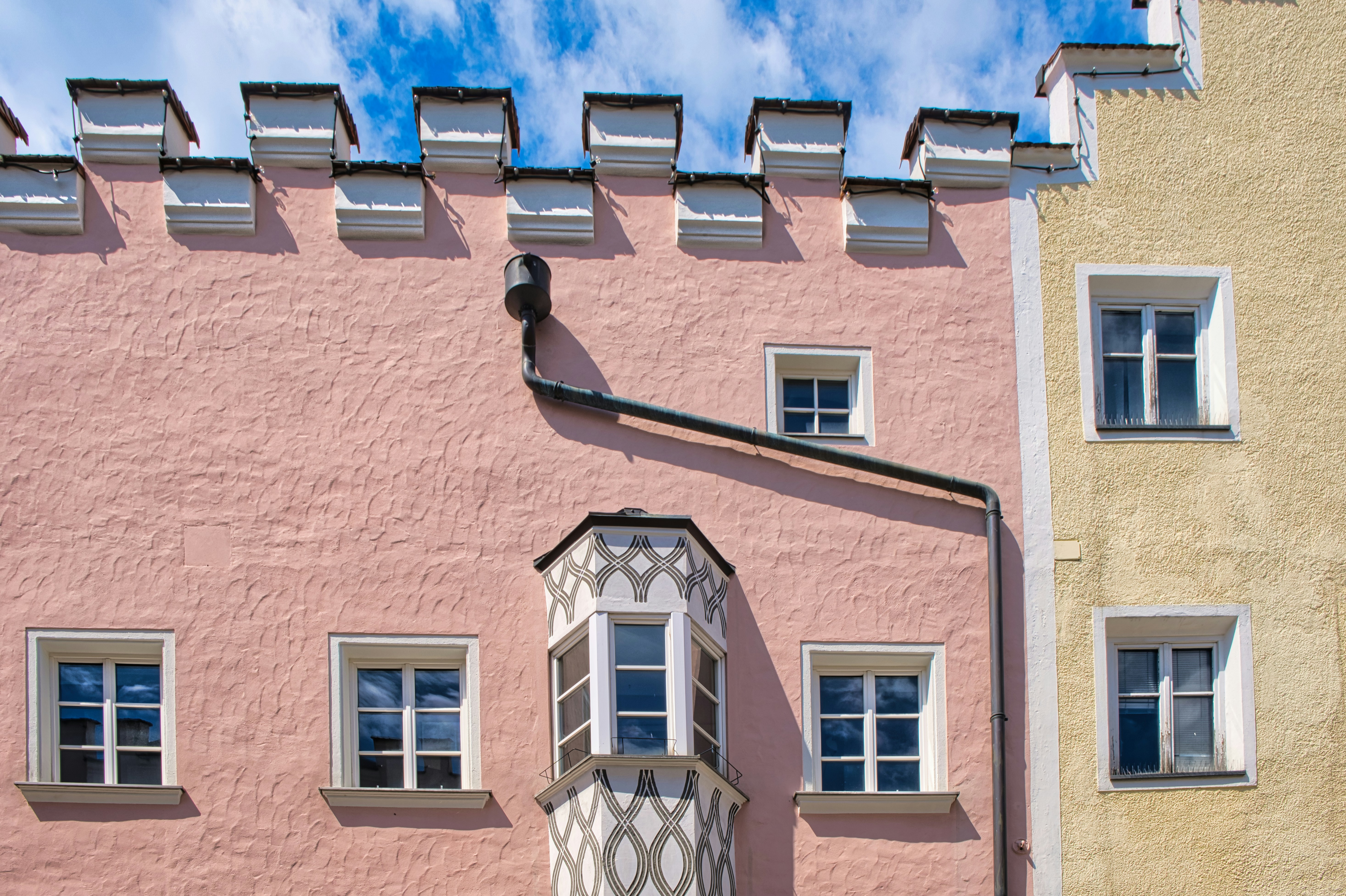 Charming pastel-colored building facades with unique architectural details, showcasing a blend of styles and textures.