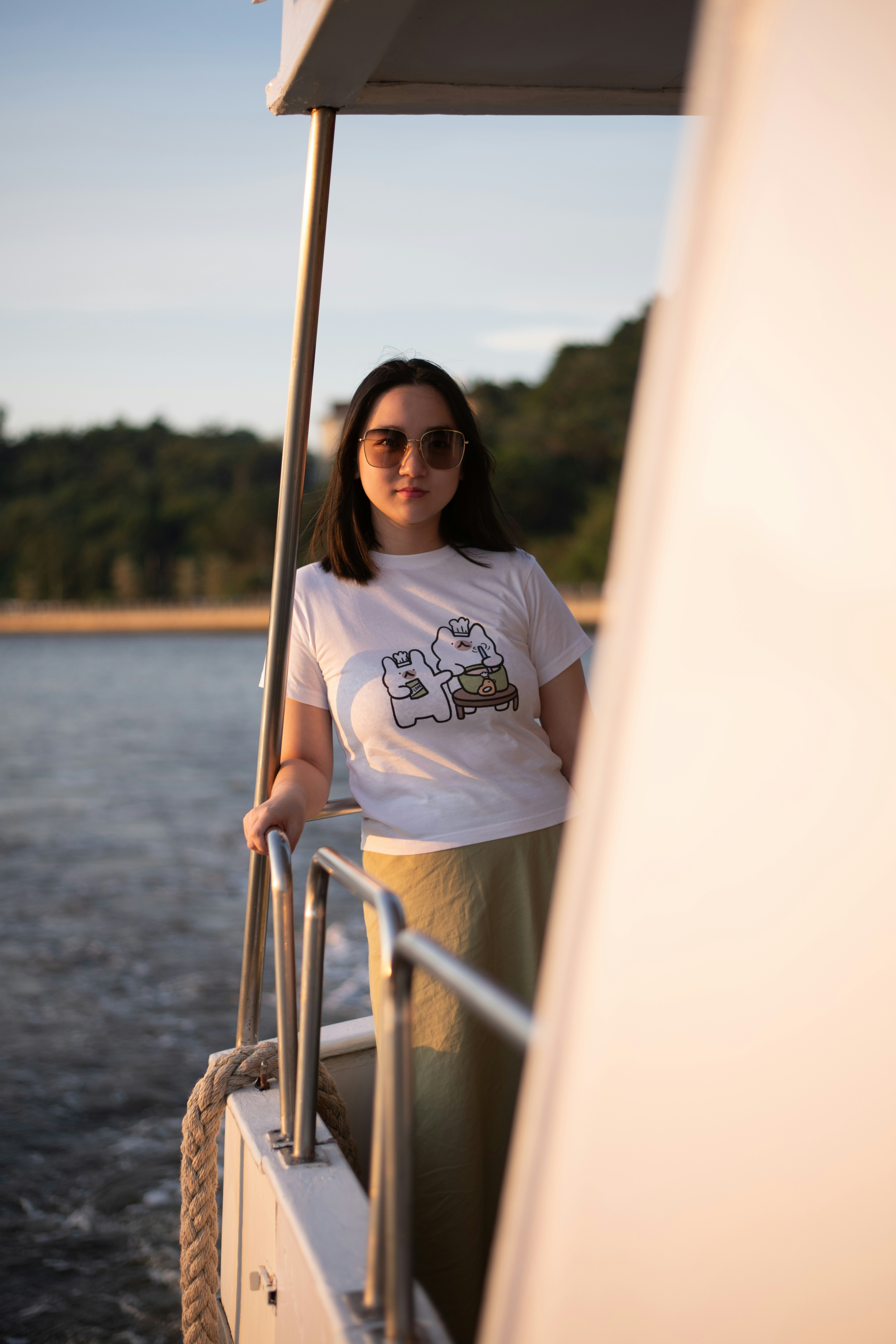 Golden Hour Deck Portrait: A Woman in White Graphic Tee on a Quiet Boat