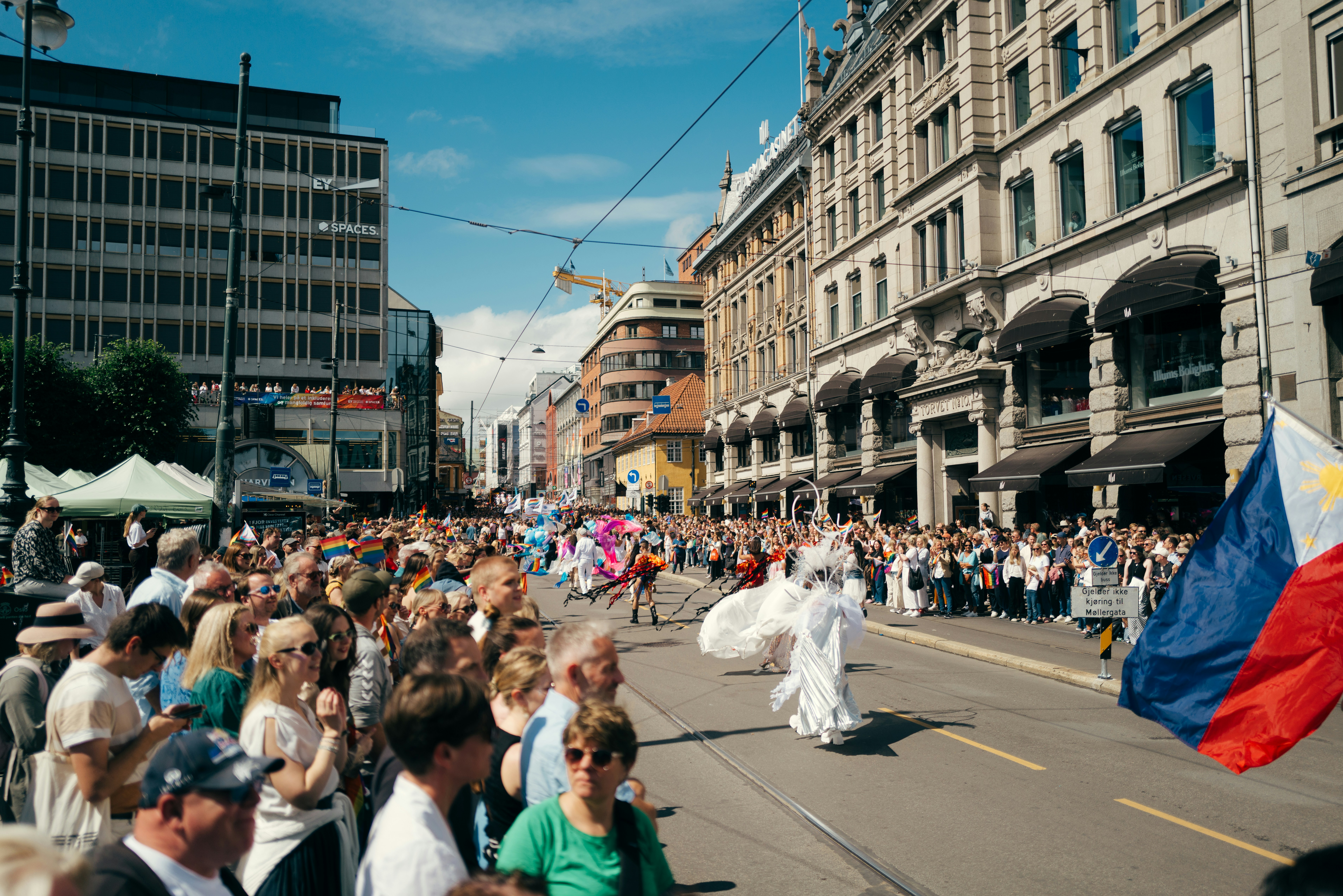 Winged Dancer Amid a Sunlit City Parade