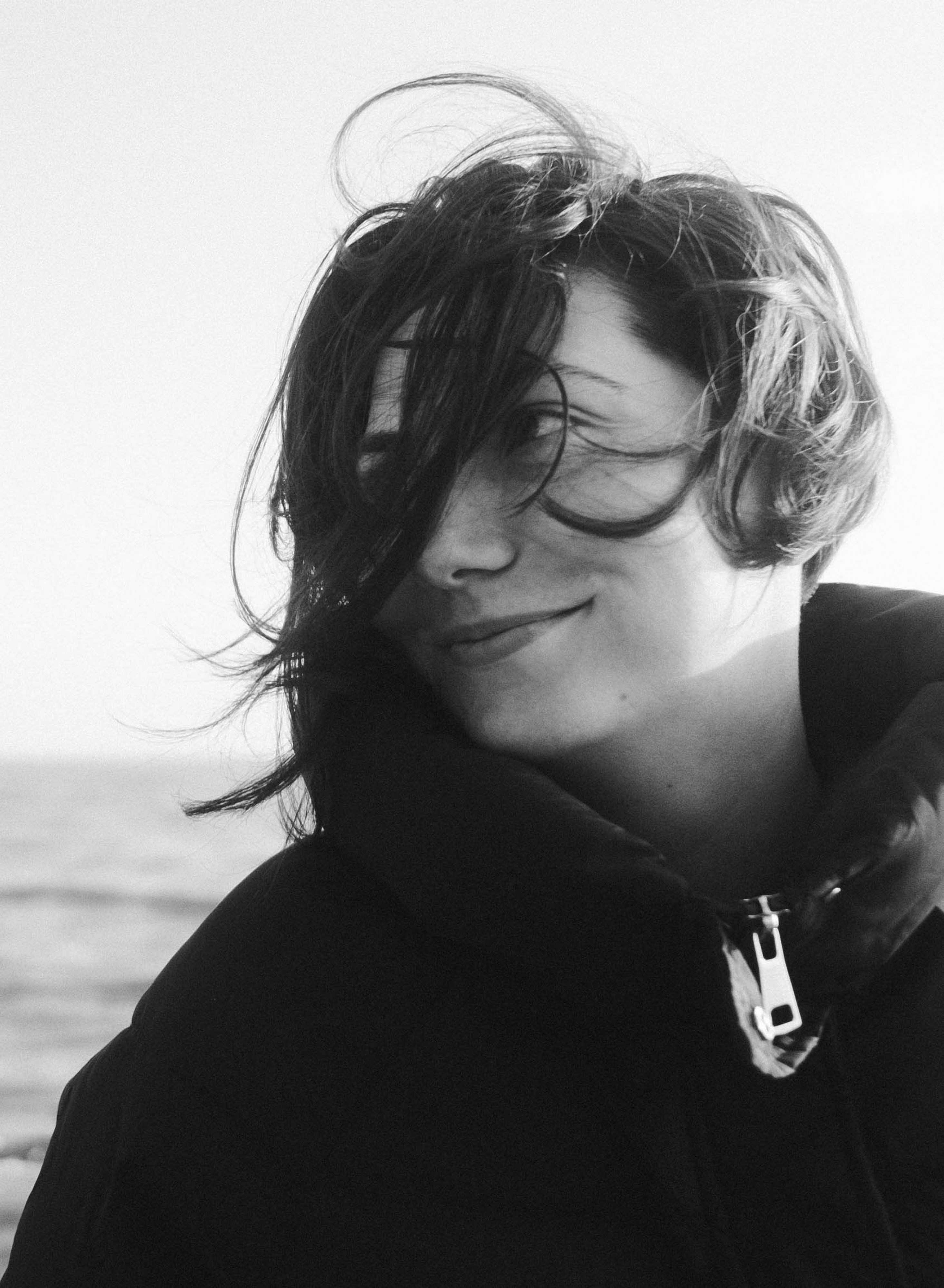 A smiling person with windblown hair. photo – Free Portrait Image on ...