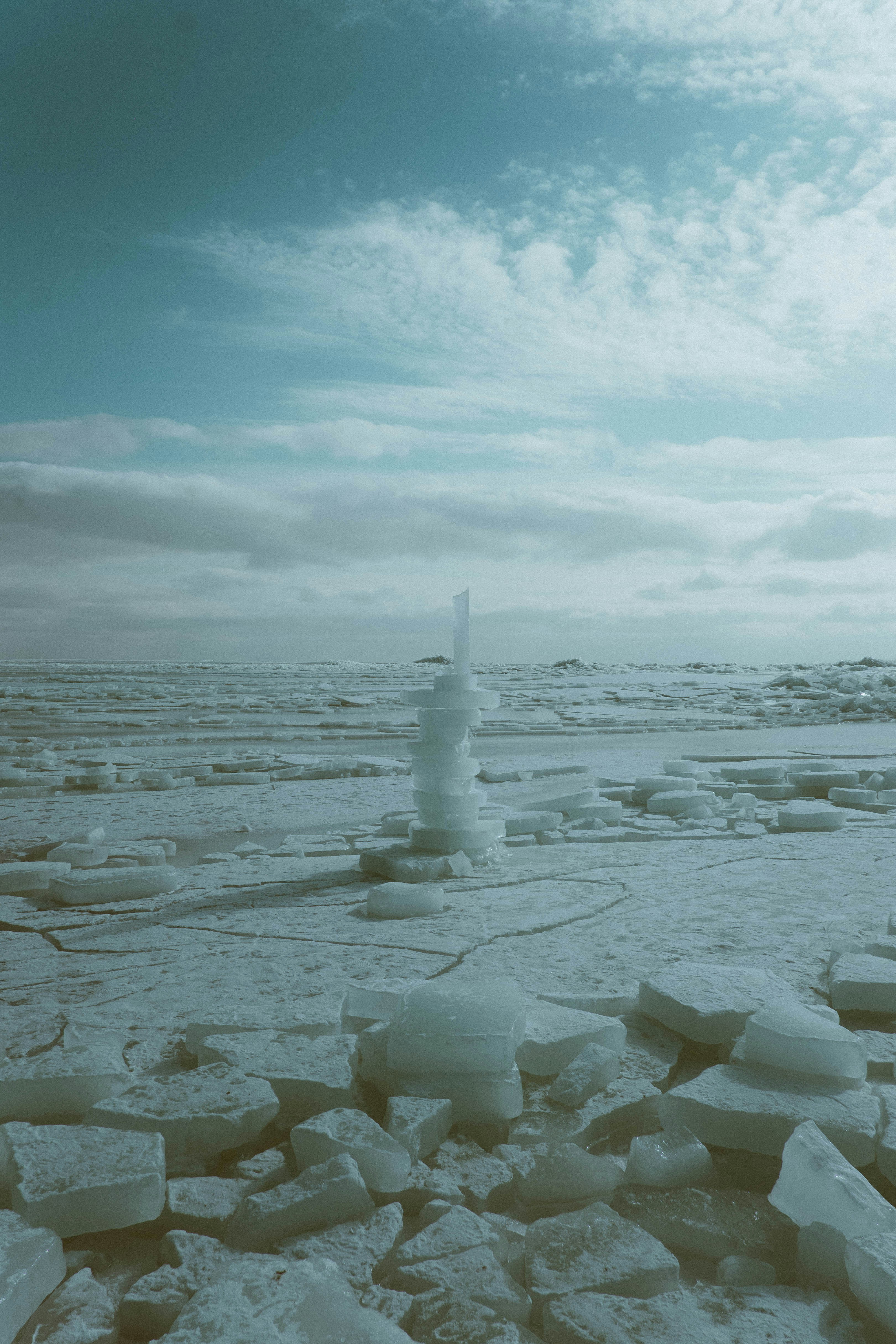 Teal-Tinted Ice Spire on a Desolate Frozen Shore