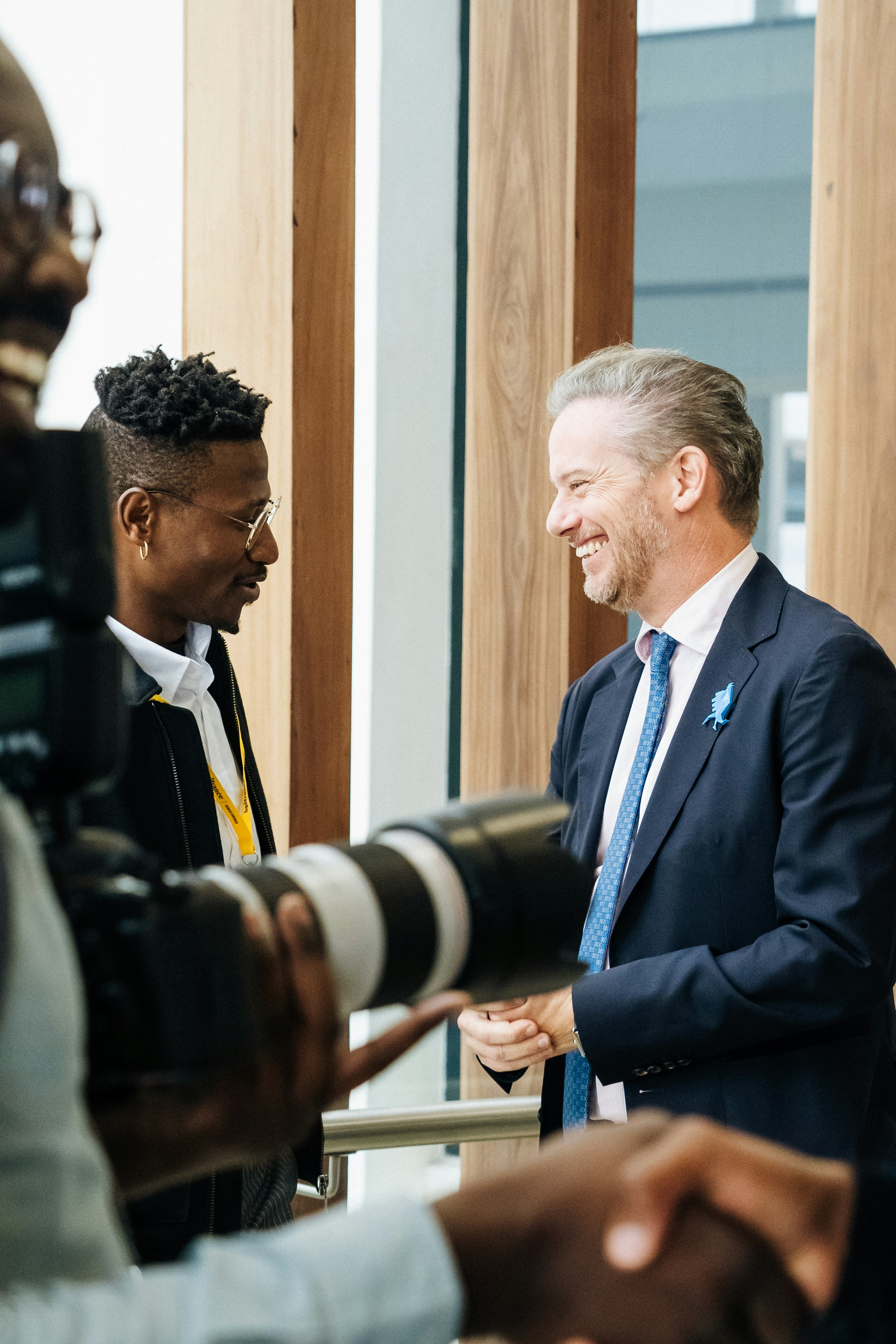 Two men greet each other while being photographed. photo – Free Art ...