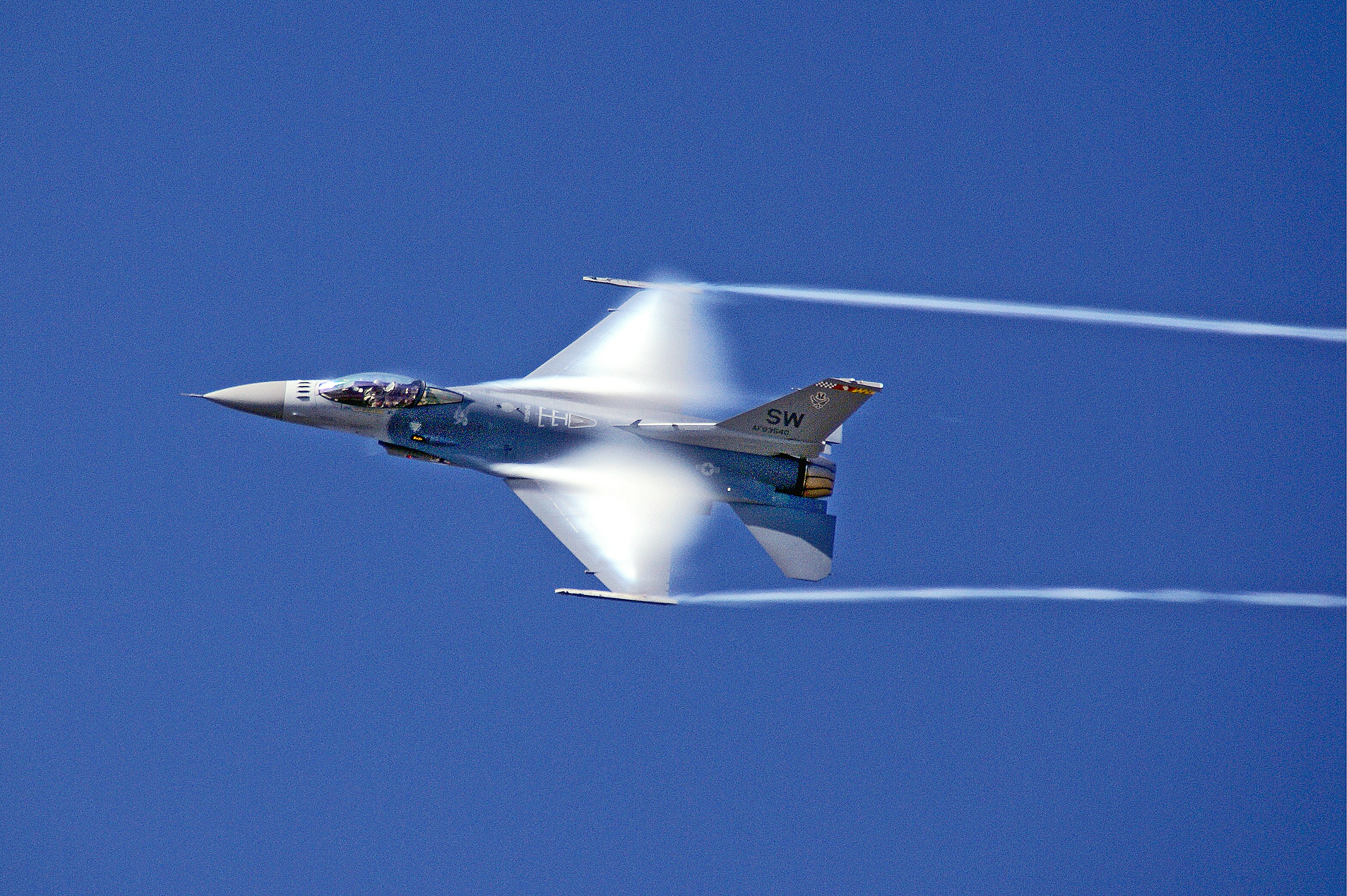 Fighter jet soaring through the sky, creating vapor trails as it approaches the speed of sound.